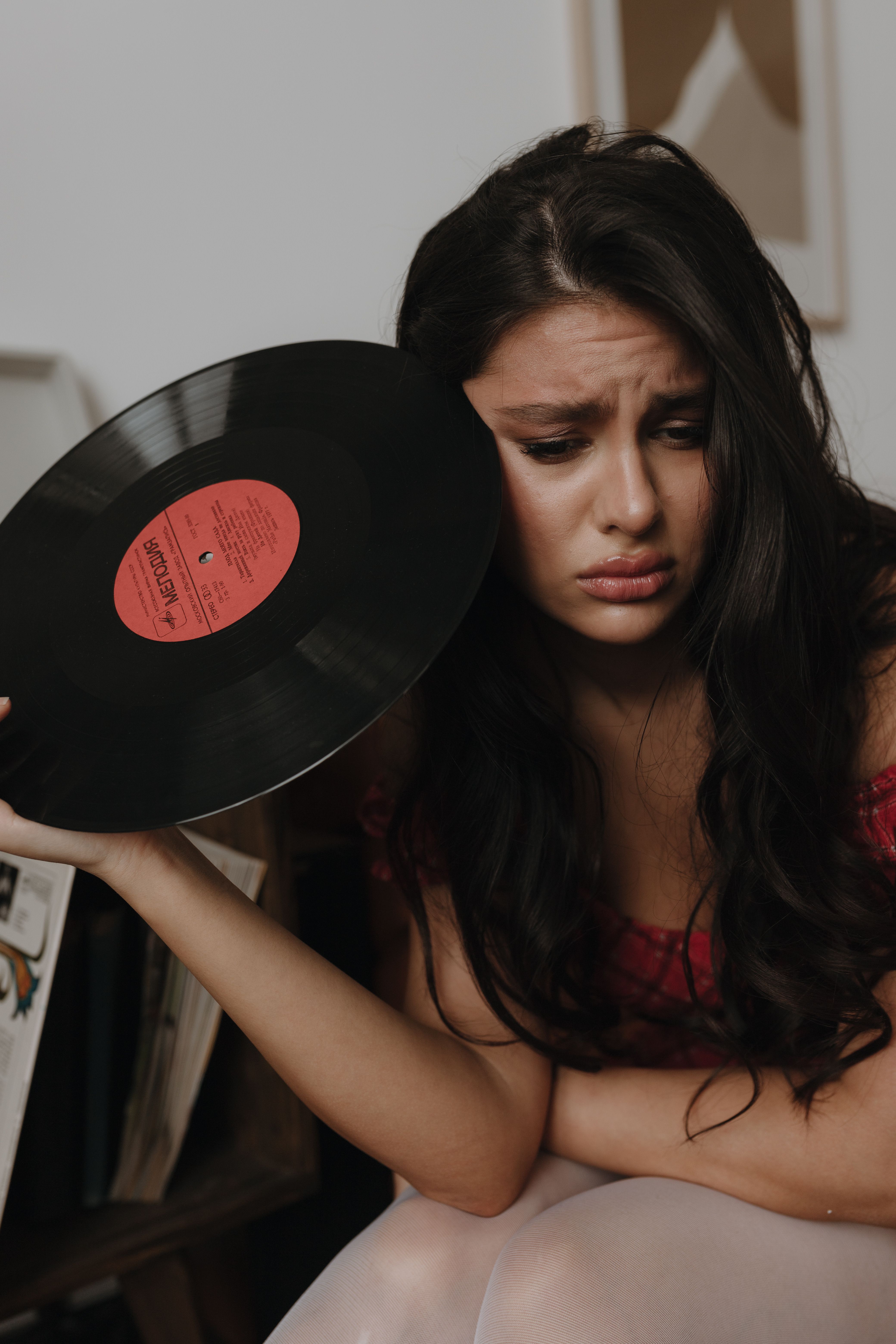Sad Brunette Posing with a Vinyl Record · Free Stock Photo