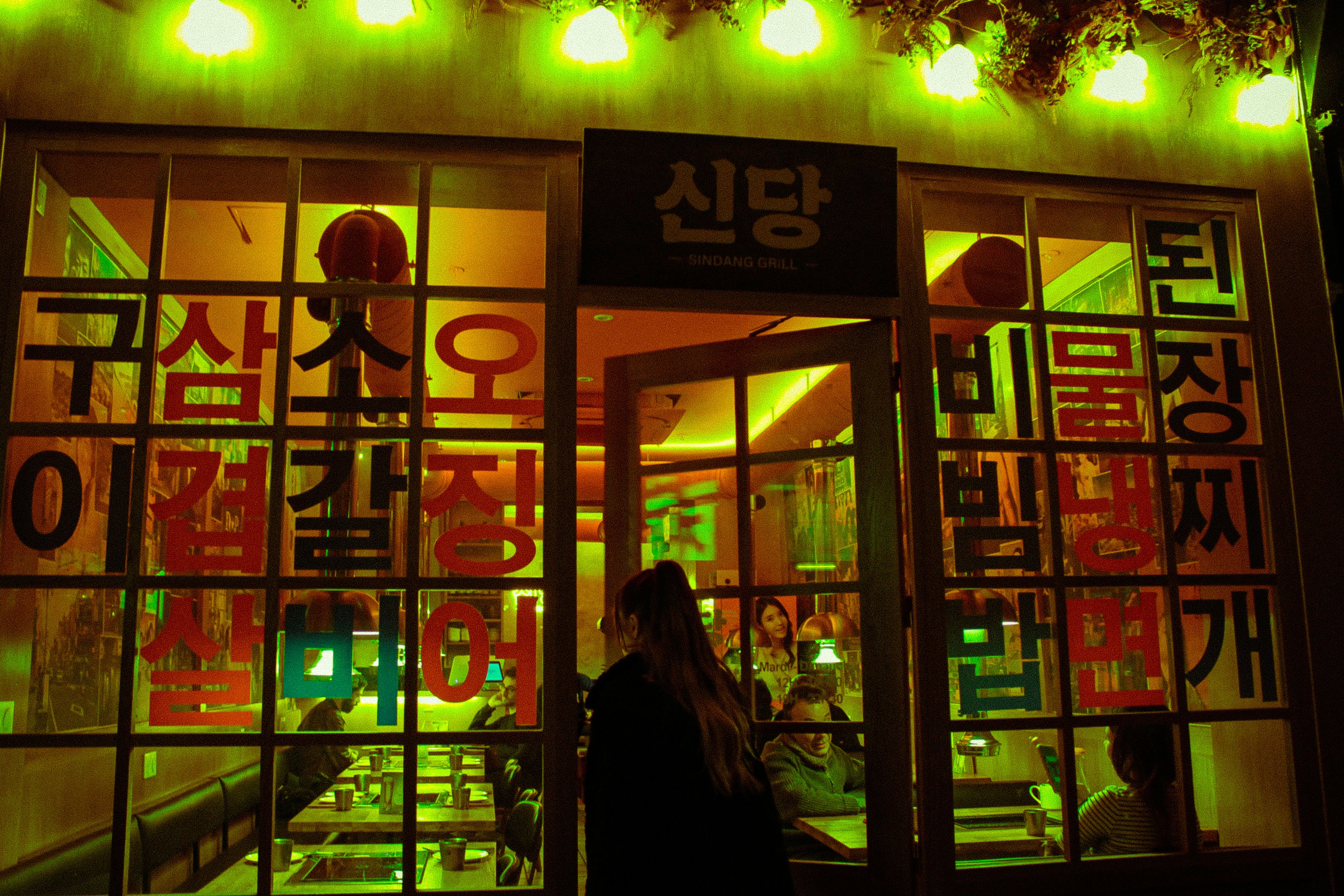 Woman Entering Asian Restaurant at Night · Free Stock Photo