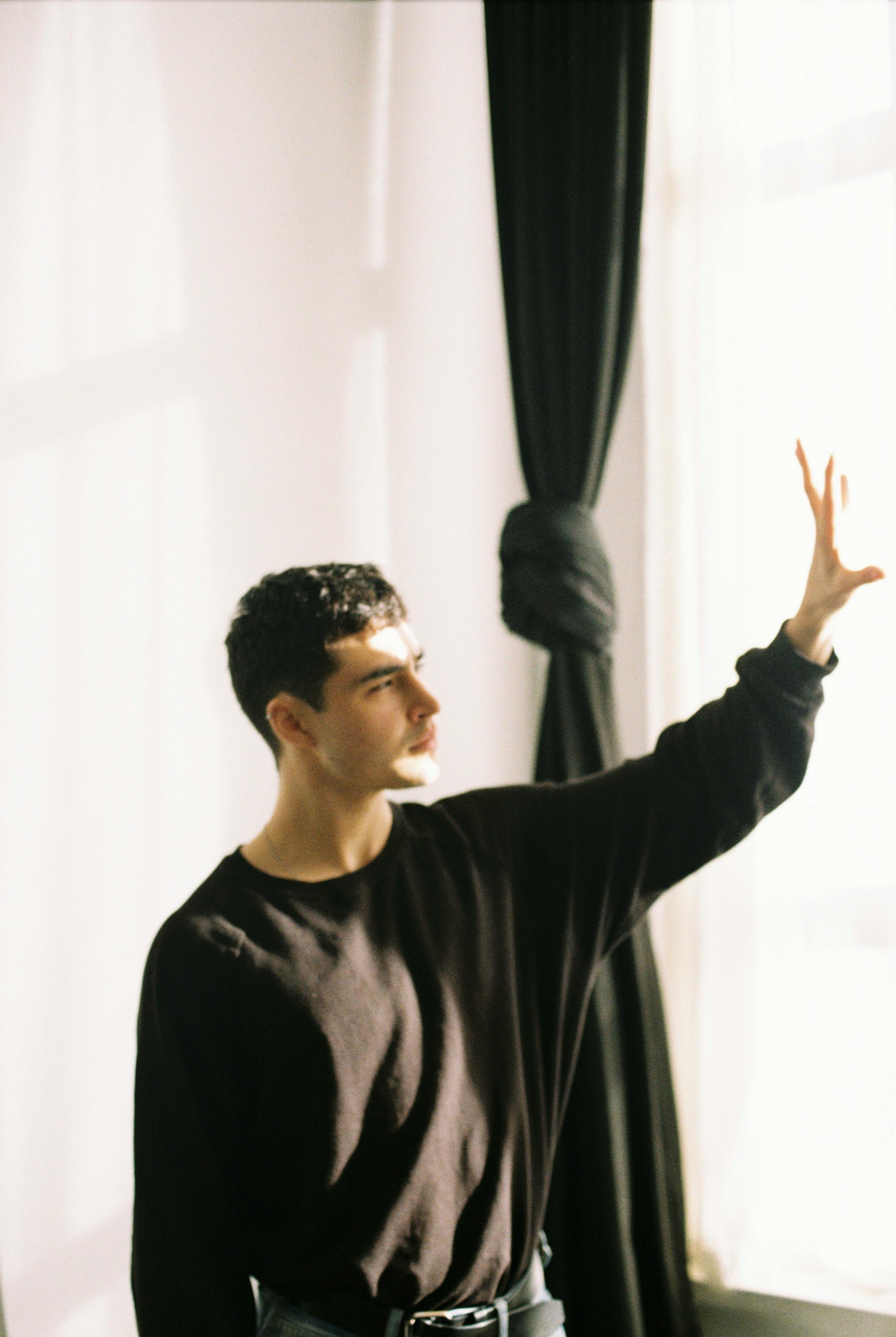 A man in black sweater reaching out for something · Free Stock Photo