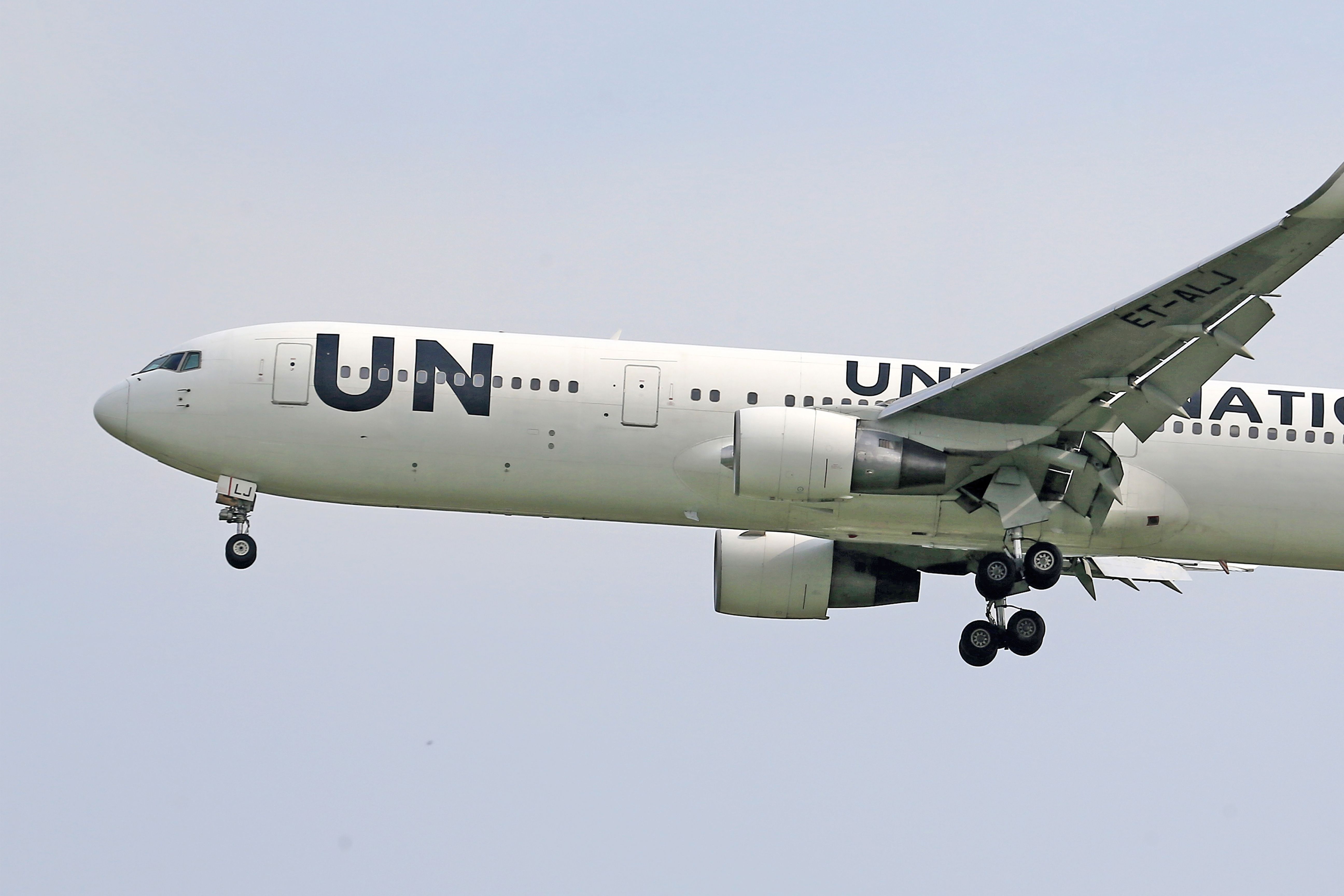 A large white and blue plane flying in the sky · Free Stock Photo