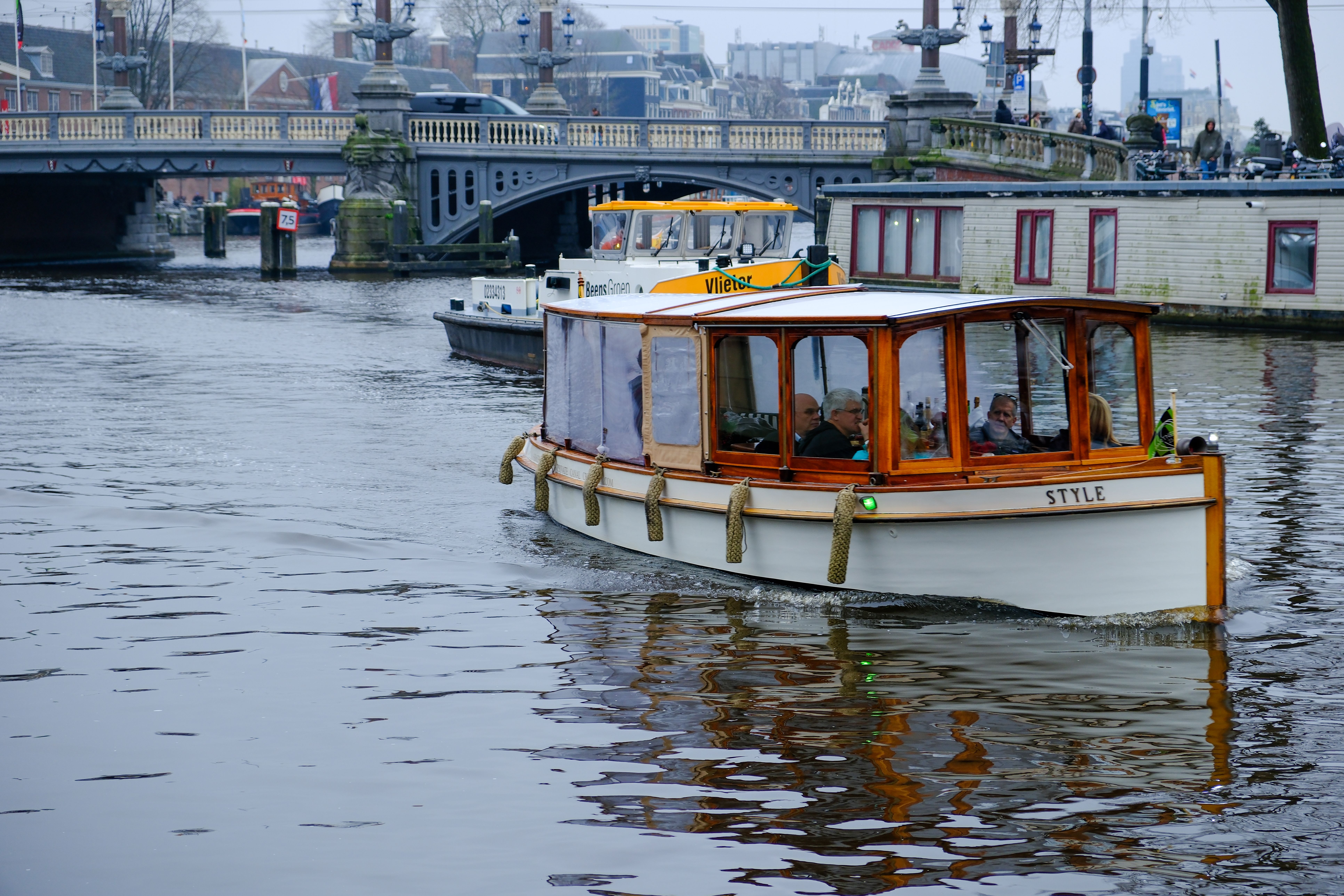 A boat on a river with a bridge in the background · Free Stock Photo