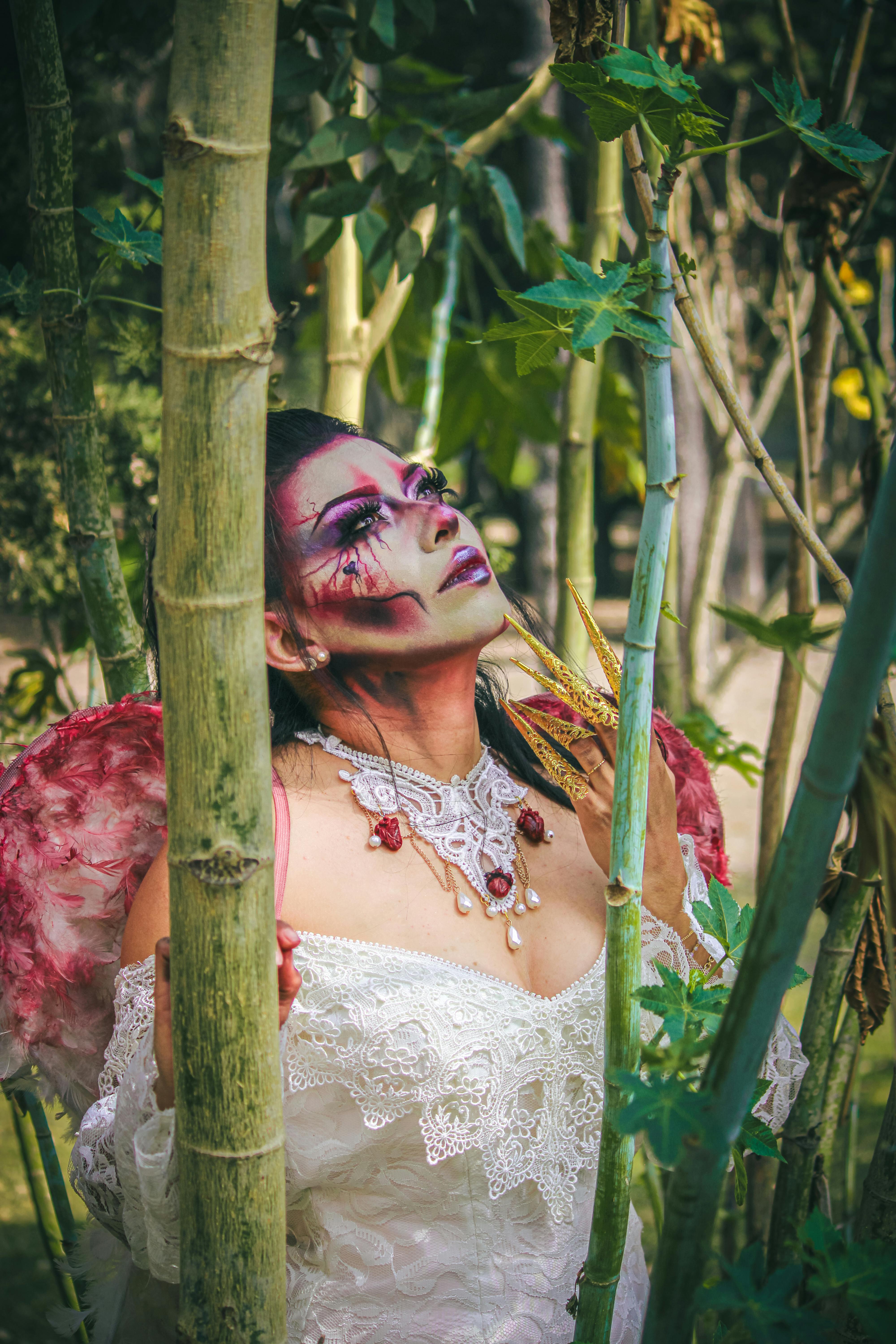 Woman in Cosplay Dress Standing among Bamboo Trees · Free Stock Photo