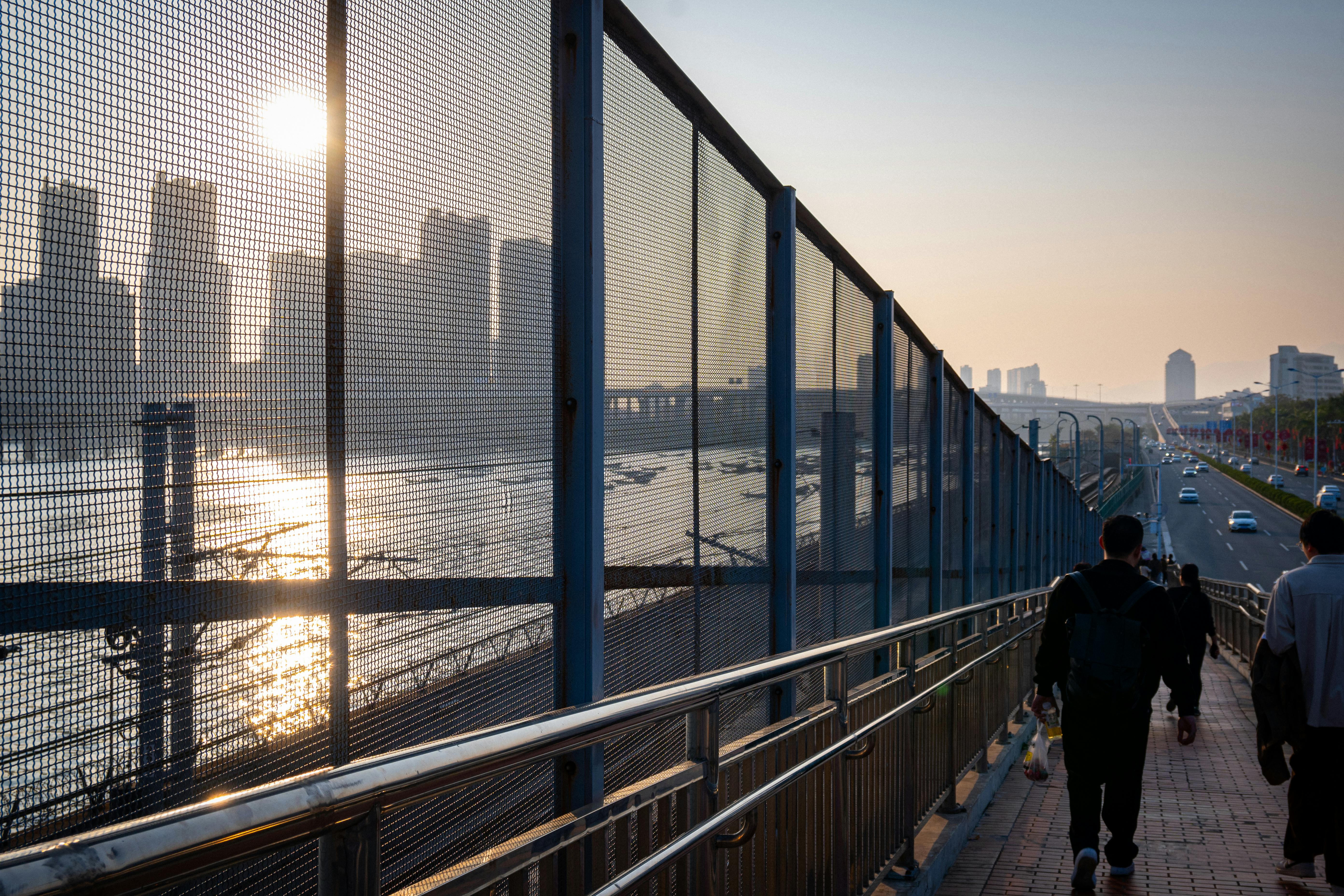 People Walking near Fence and Railing · Free Stock Photo