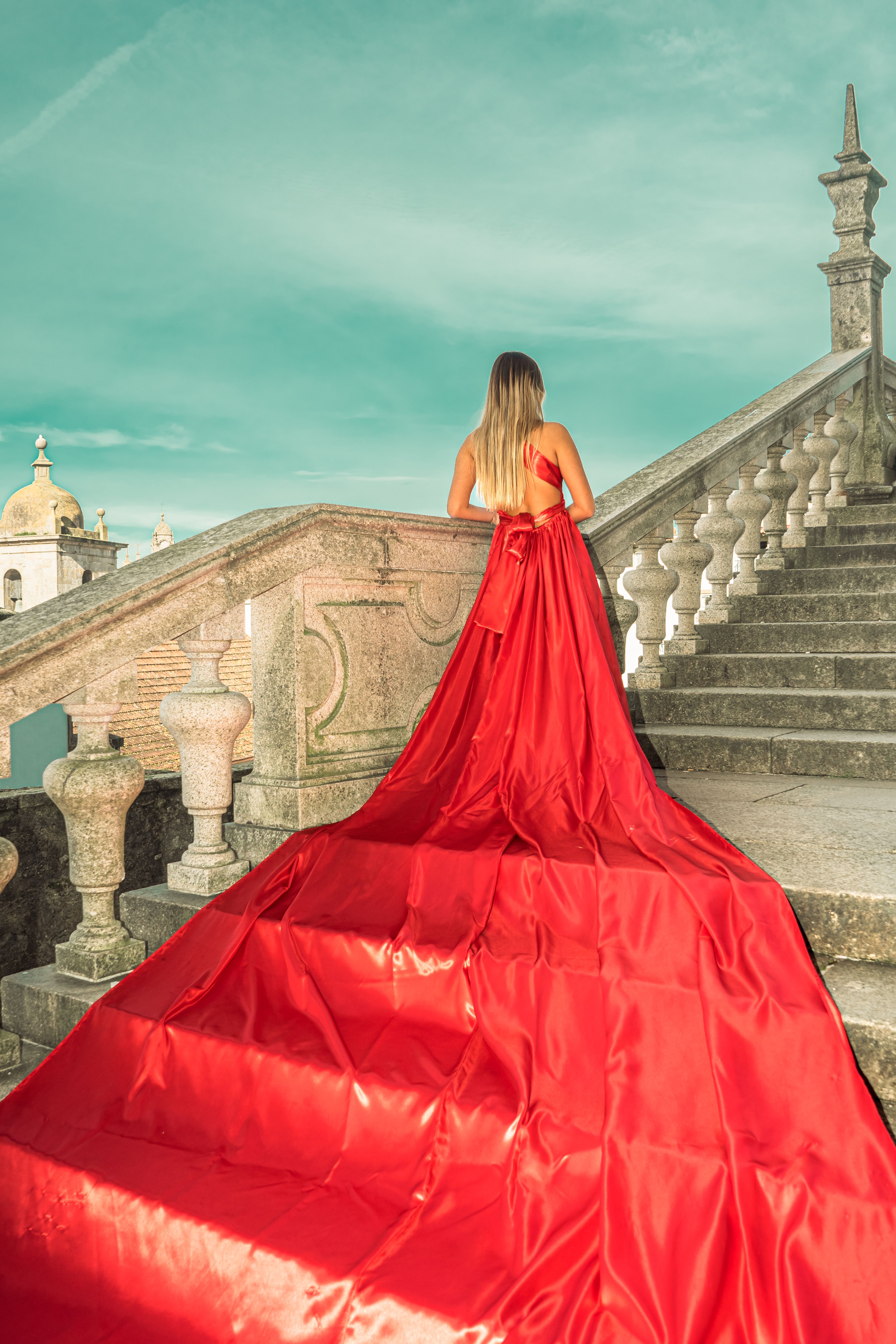 Model in Red Ball Gown on Stone Stairs · Free Stock Photo