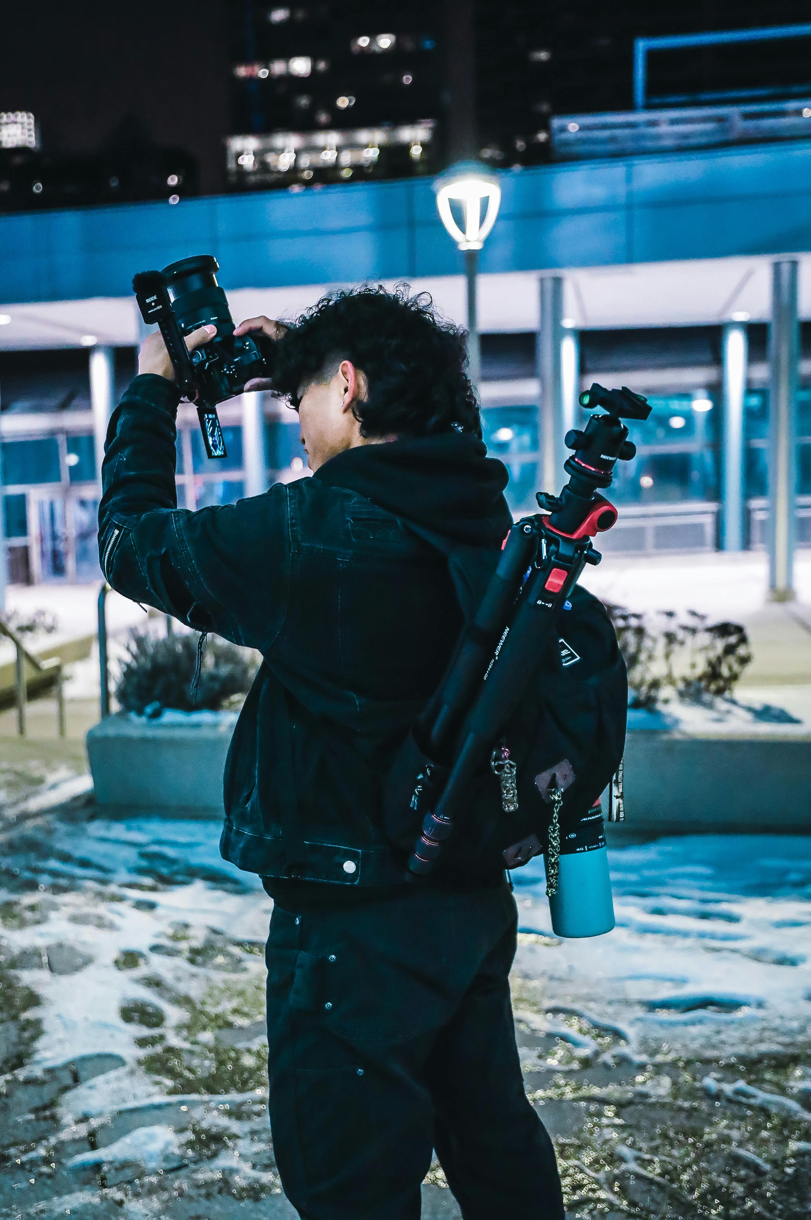 Back View of Man Standing with Camera and Tripod in City in Winter ...
