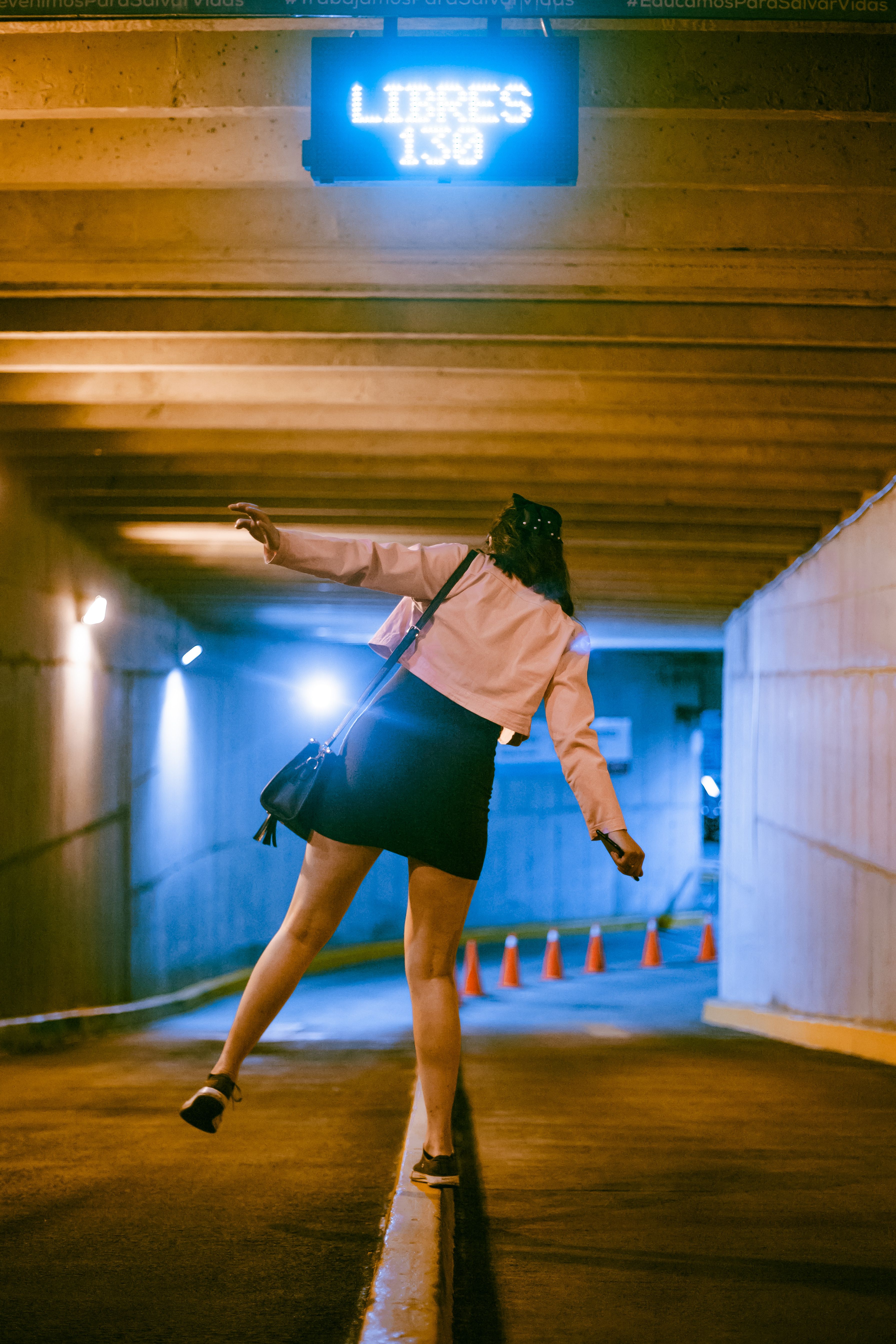 Back View of a Woman Standing in a Tunnel in City · Free Stock Photo