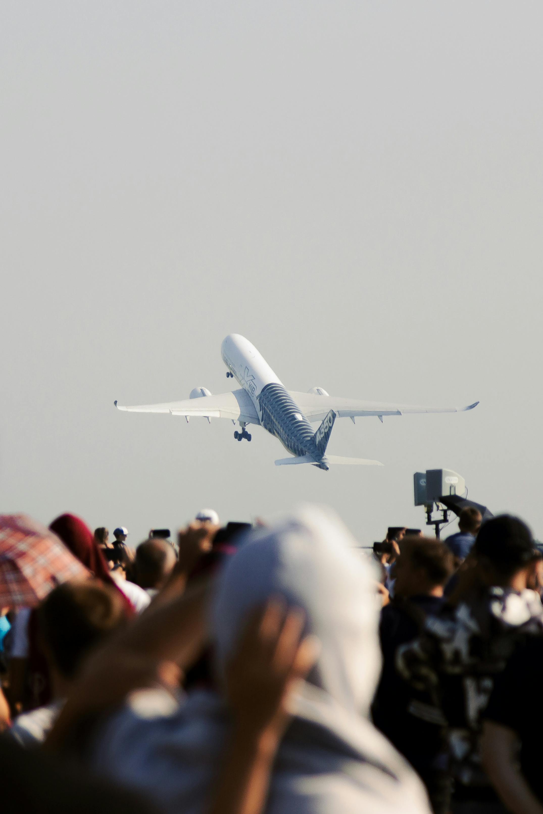A Crowd Watching a Flying Airplane · Free Stock Photo