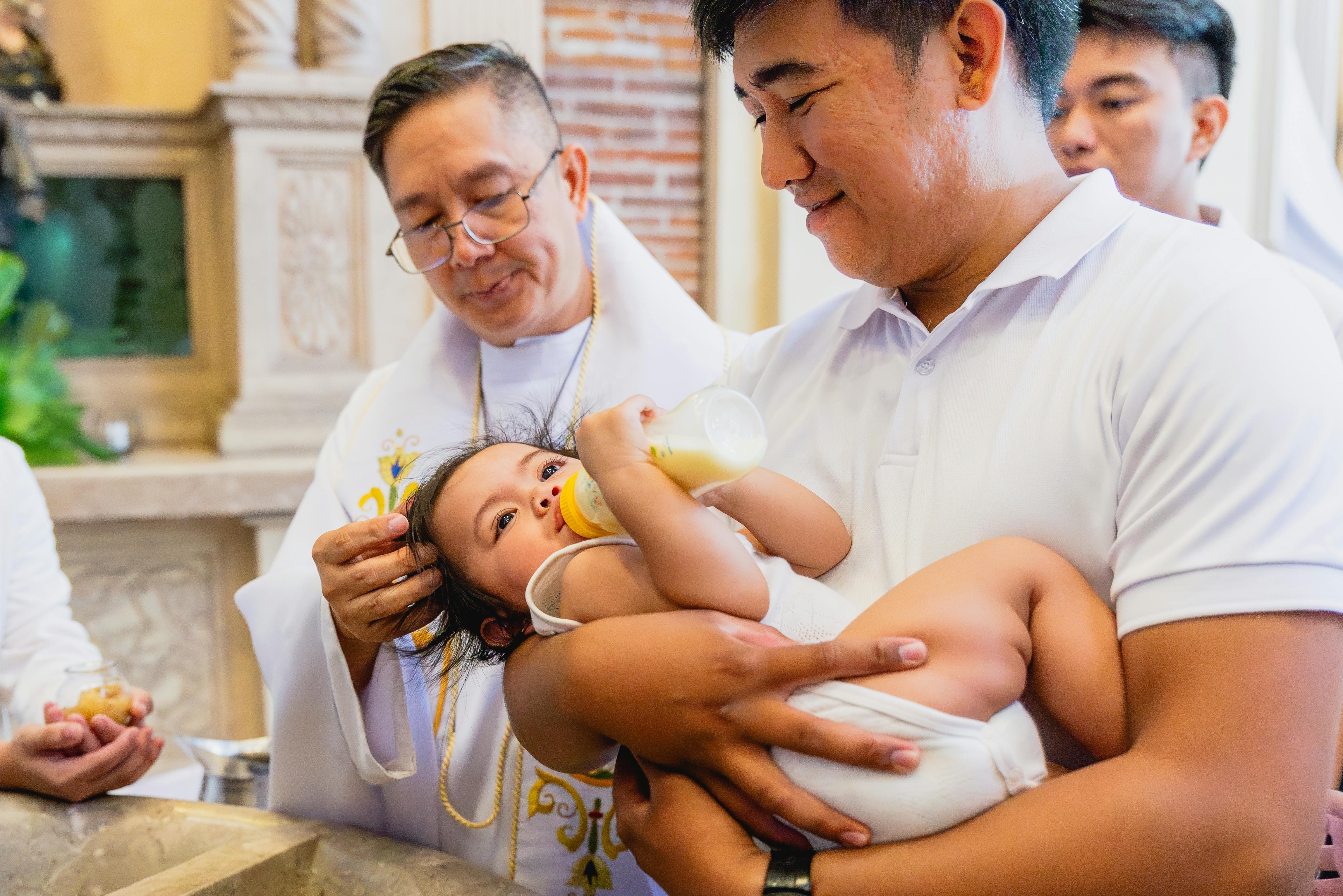 Smiling Father Holding Baby at Baptism · Free Stock Photo