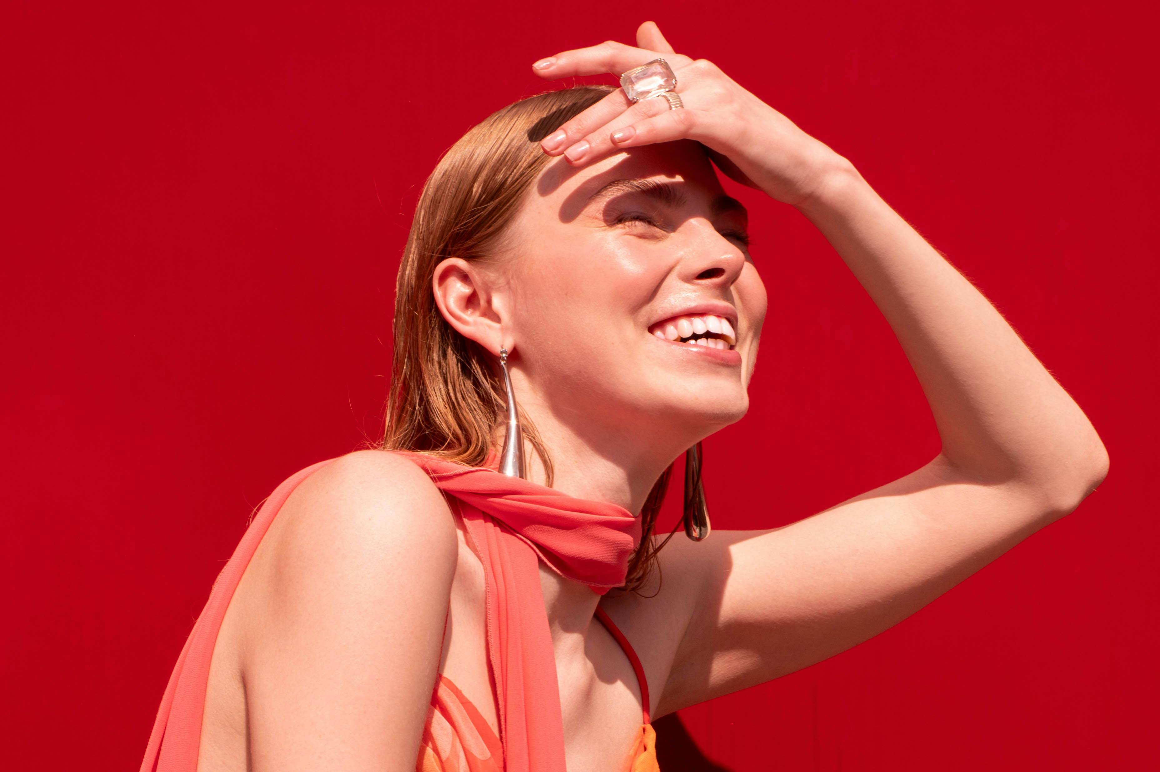 Smiling Woman with Hand over Forehead · Free Stock Photo