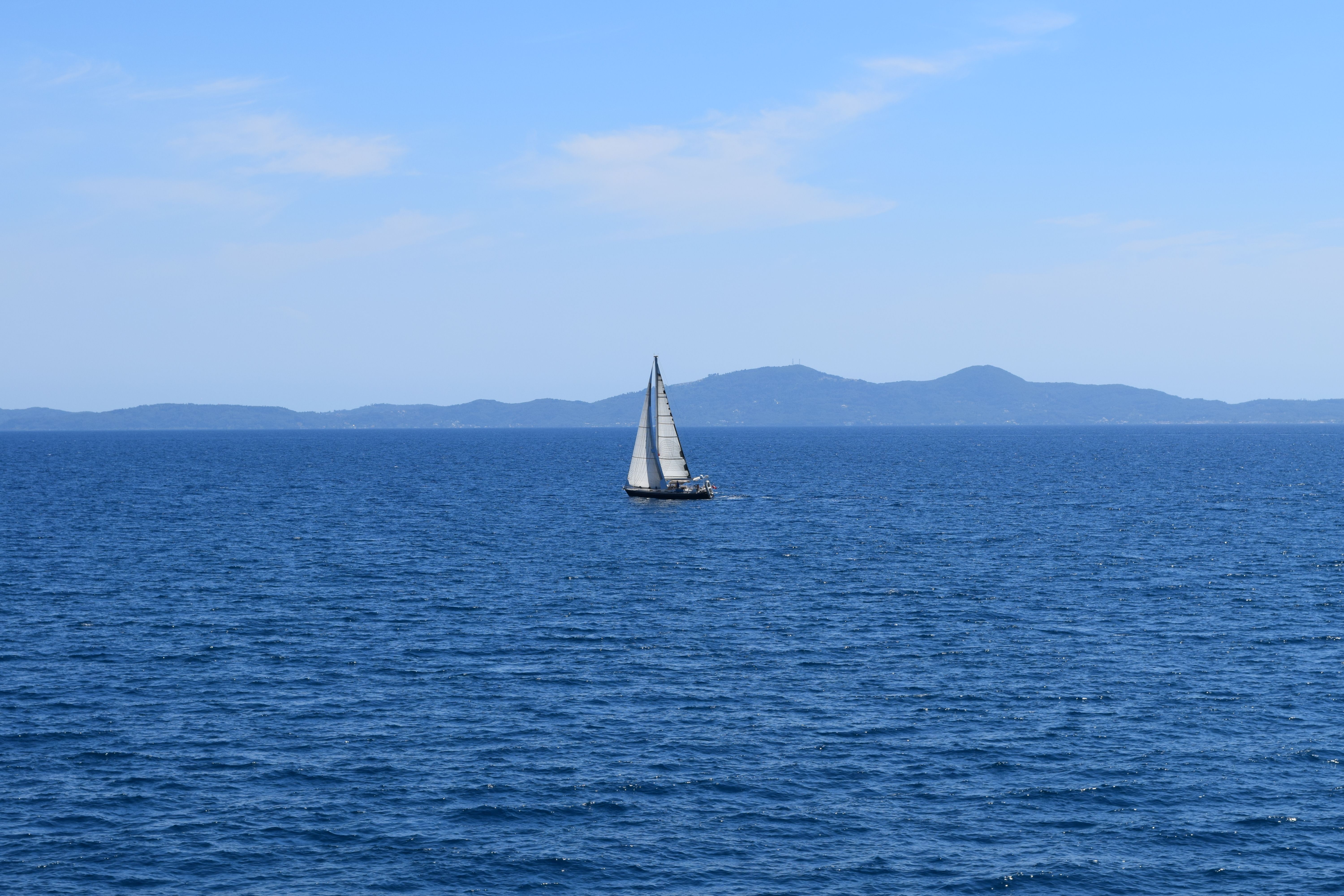 Sailboat Sailing on Sea Coast · Free Stock Photo