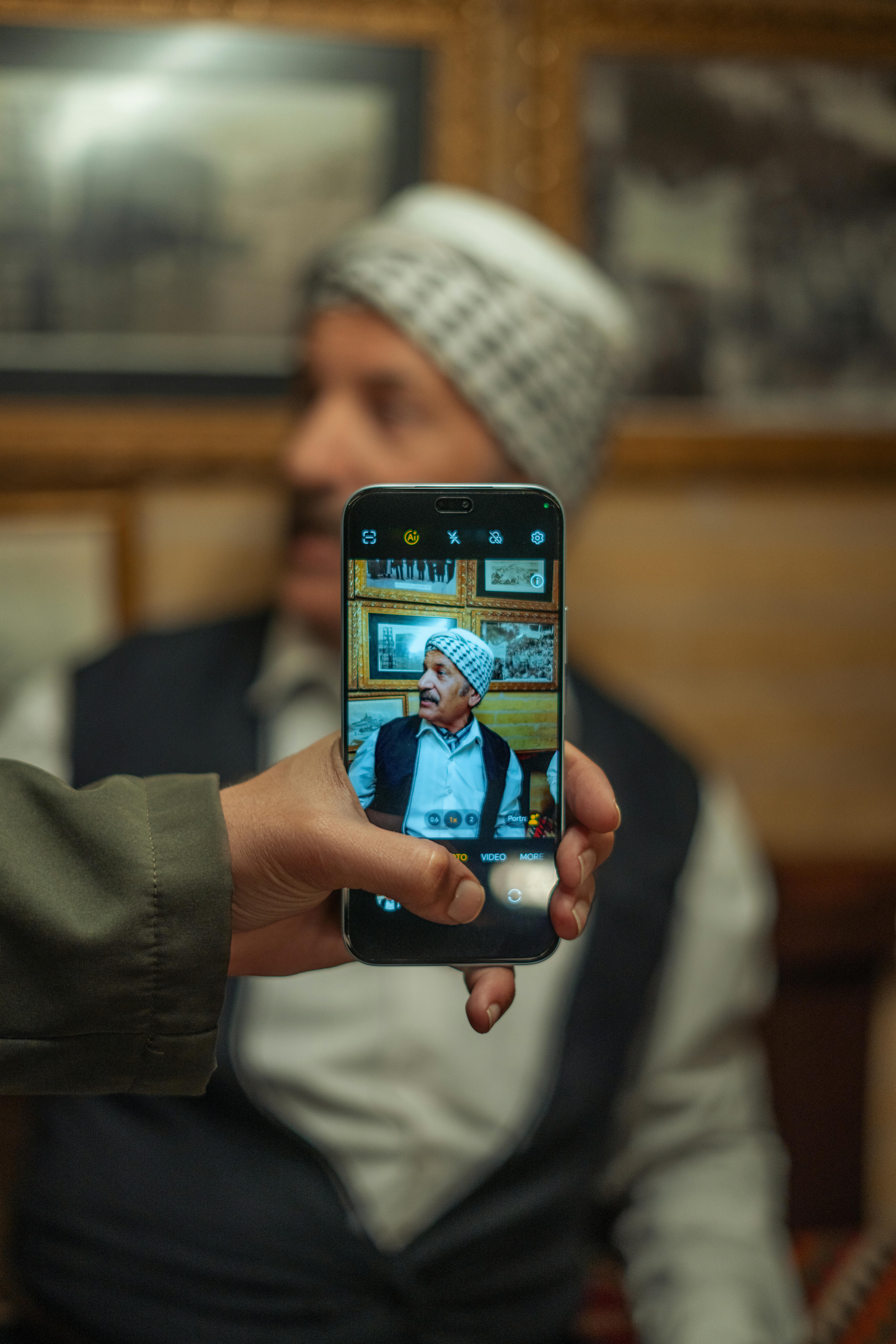 Tilt Shift Photo of Man Holding Black Smartphone Taking Photo of Gray ...