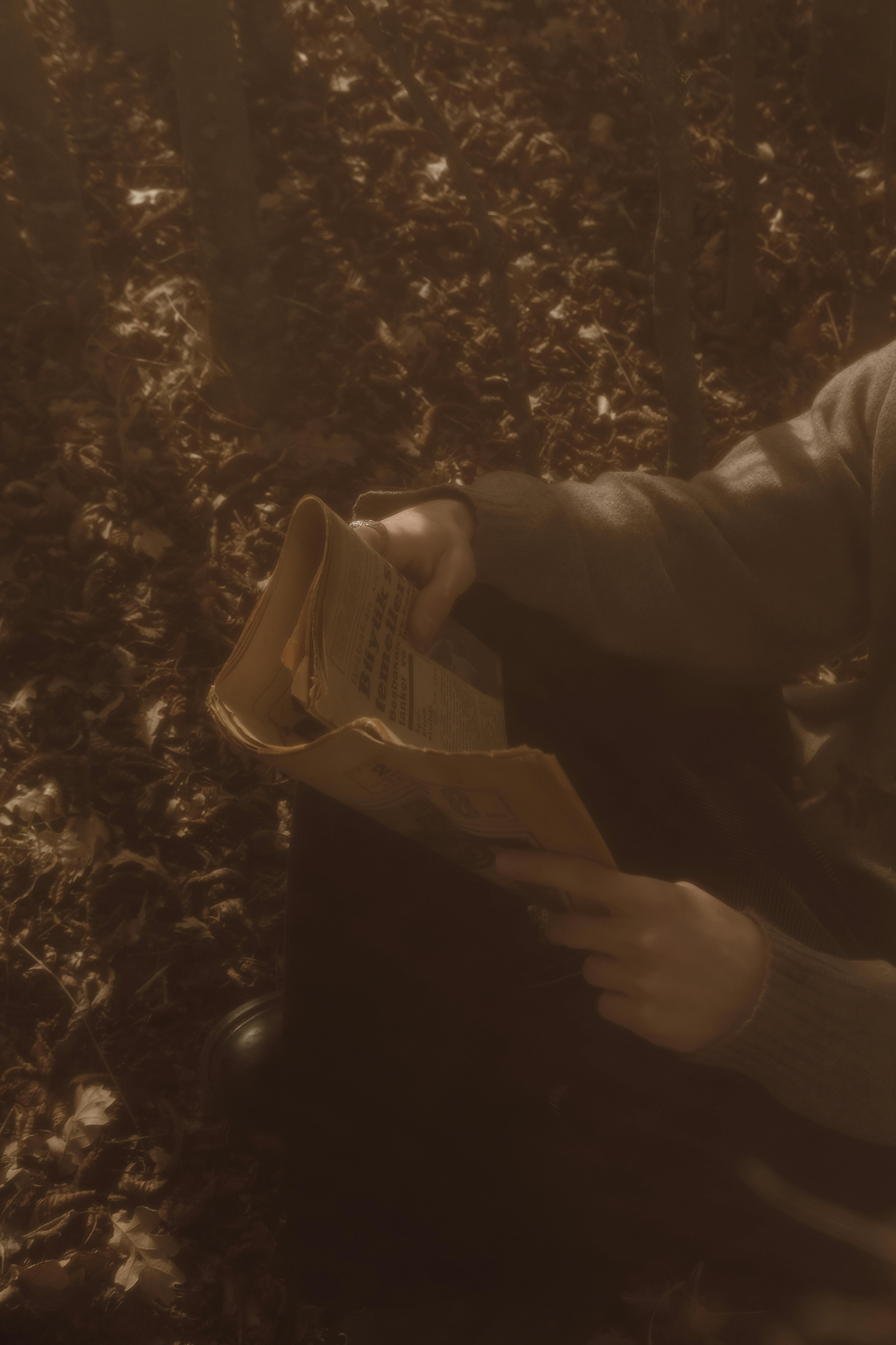 Sepia Toned Photo of a Person Sitting on the Ground with a Newspaper ...