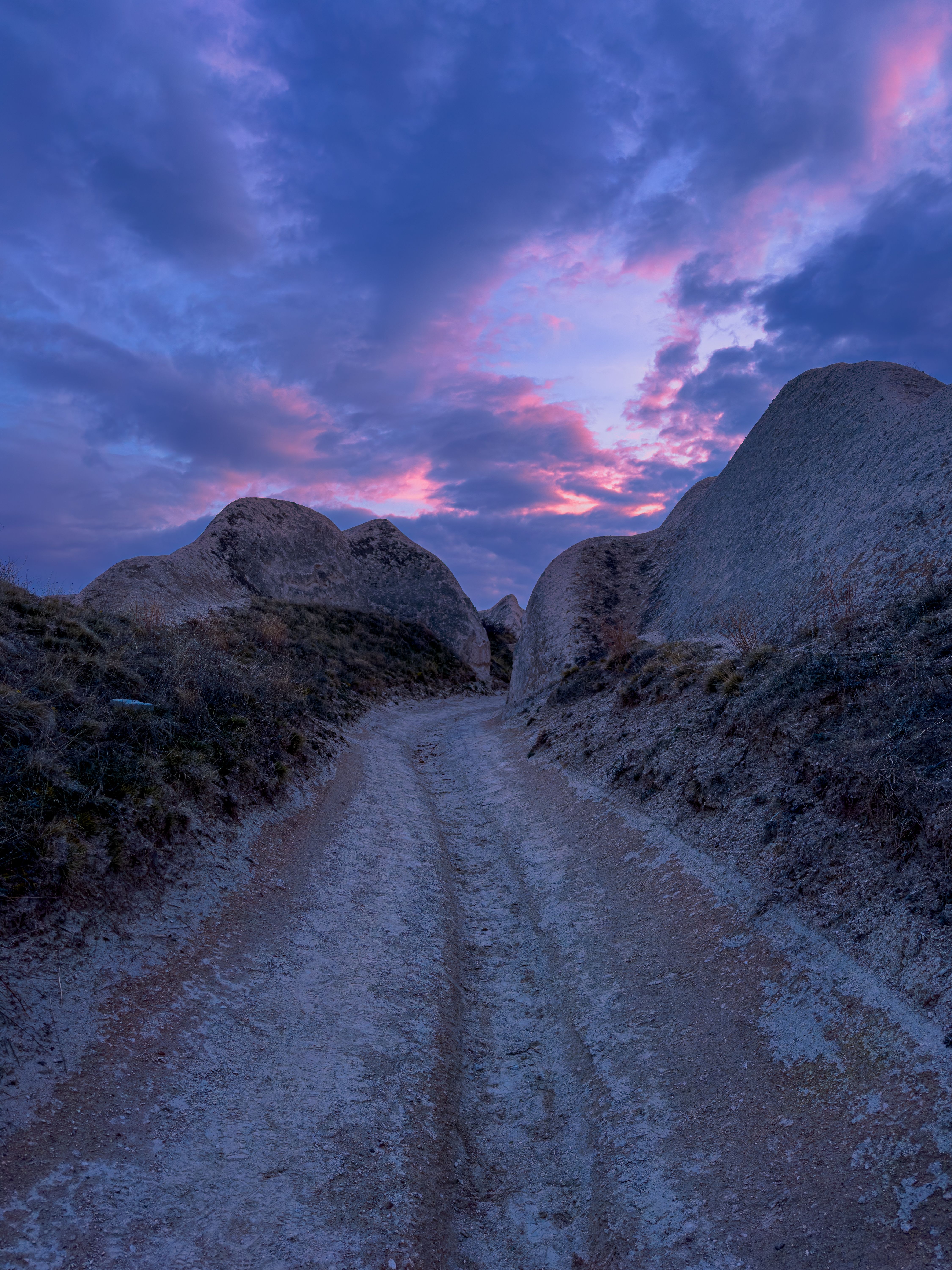 Dirt Road among Rocky Hills under Clouds · Free Stock Photo