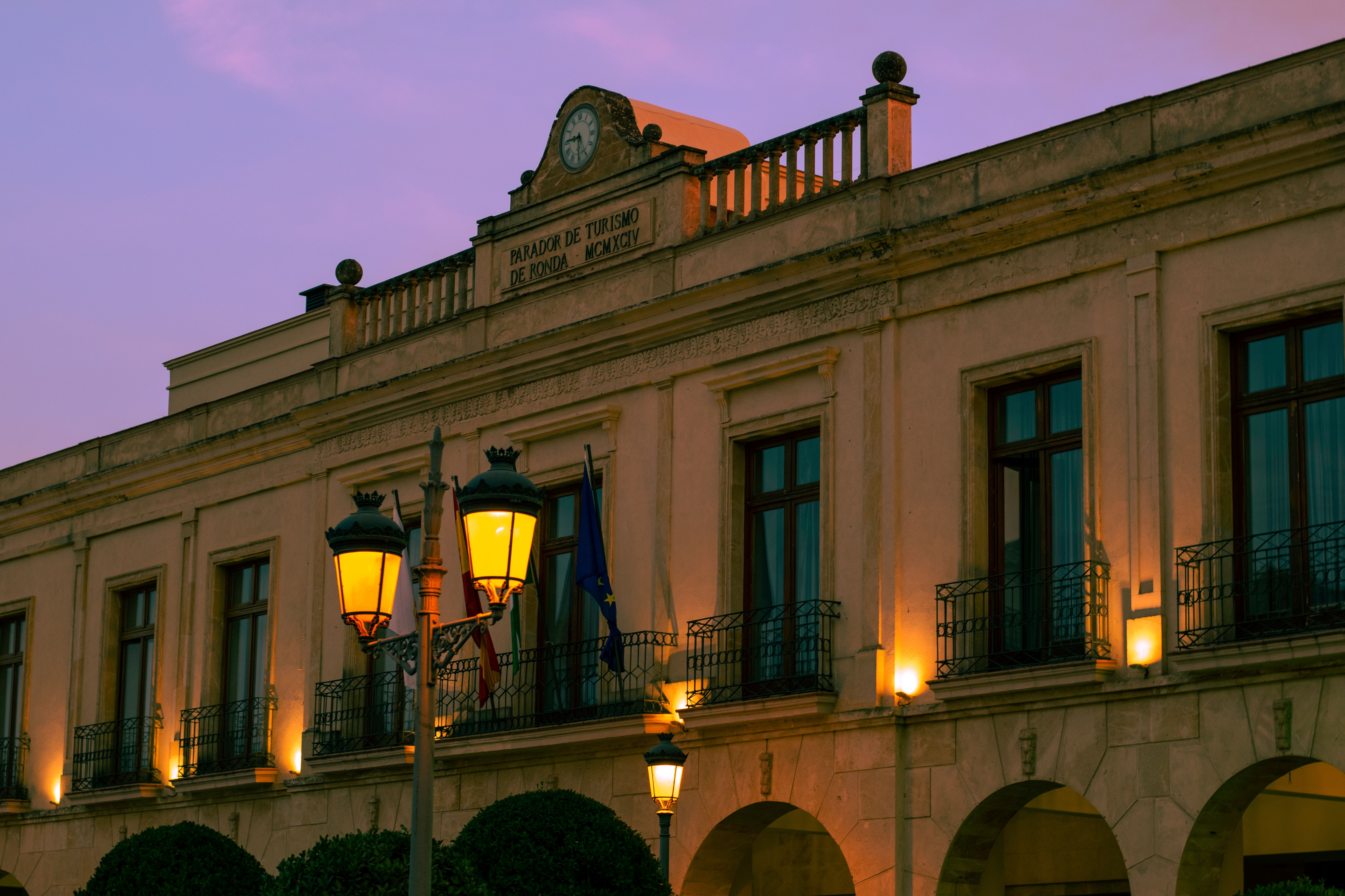A building with a clock tower and street lamps · Free Stock Photo