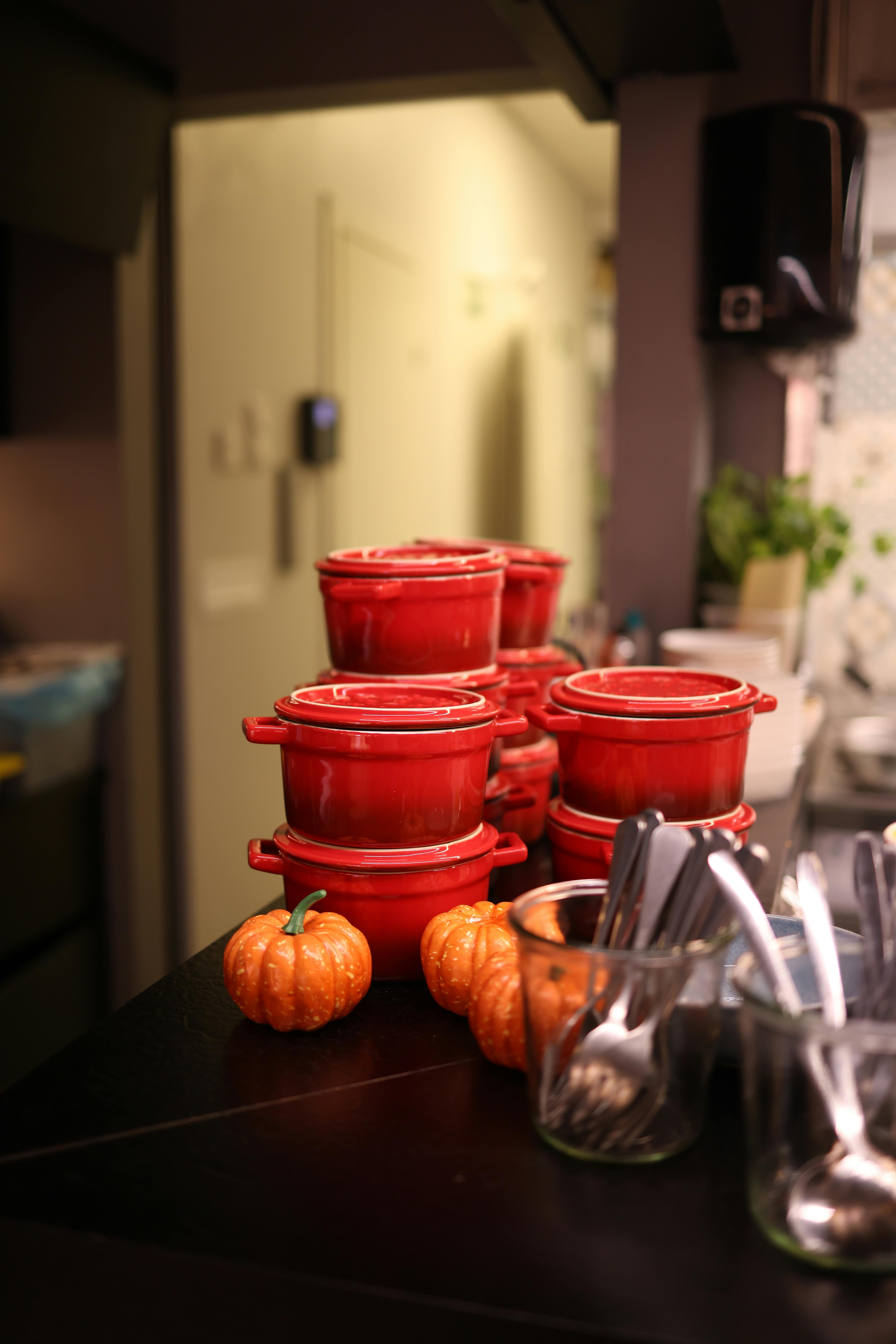 A Stack of Pots, Cutlery and Small Pumpkins on a Kitchen Countertop ...