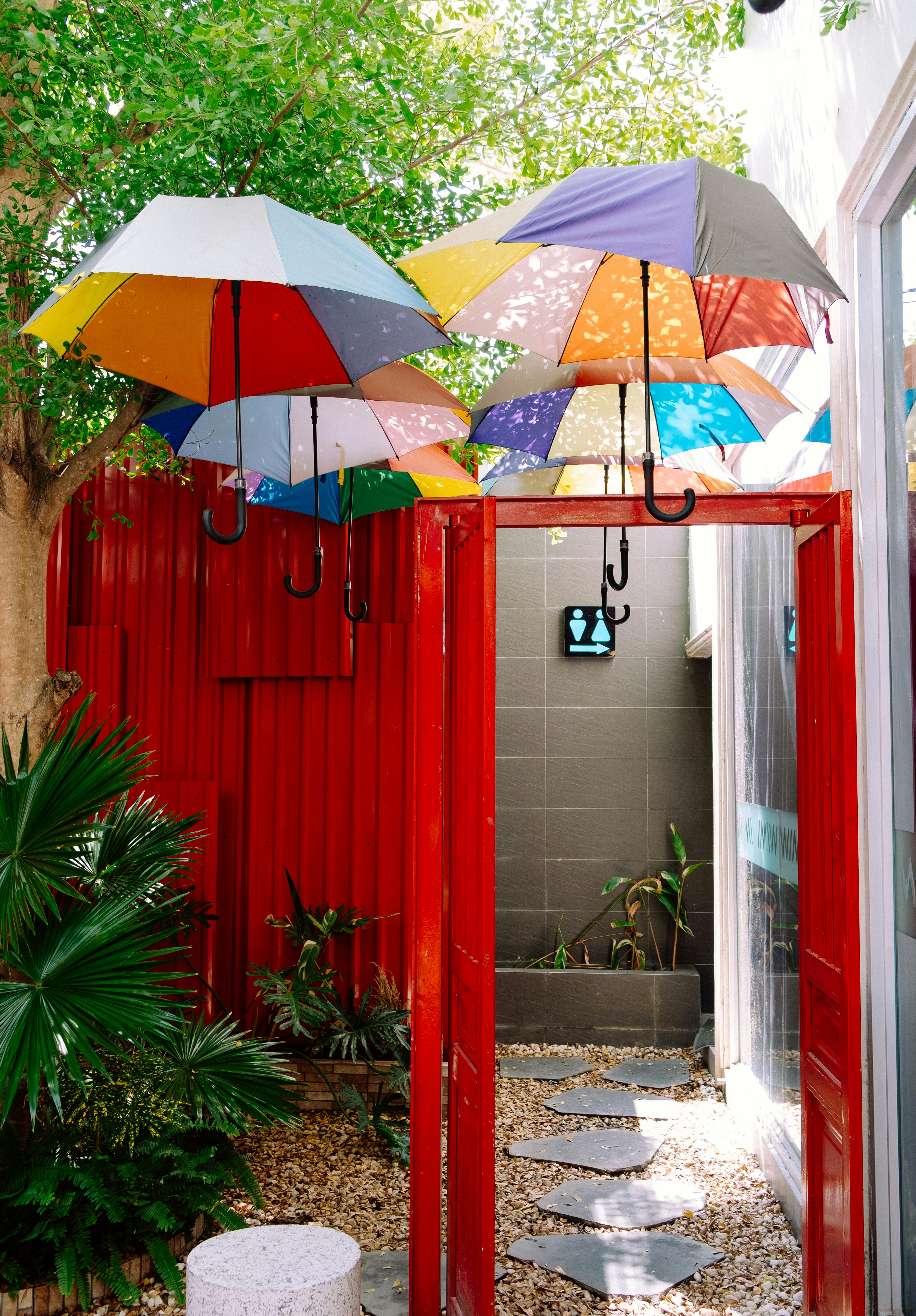 Colorful Umbrellas over Doorway to Bathroom in Garden · Free Stock Photo