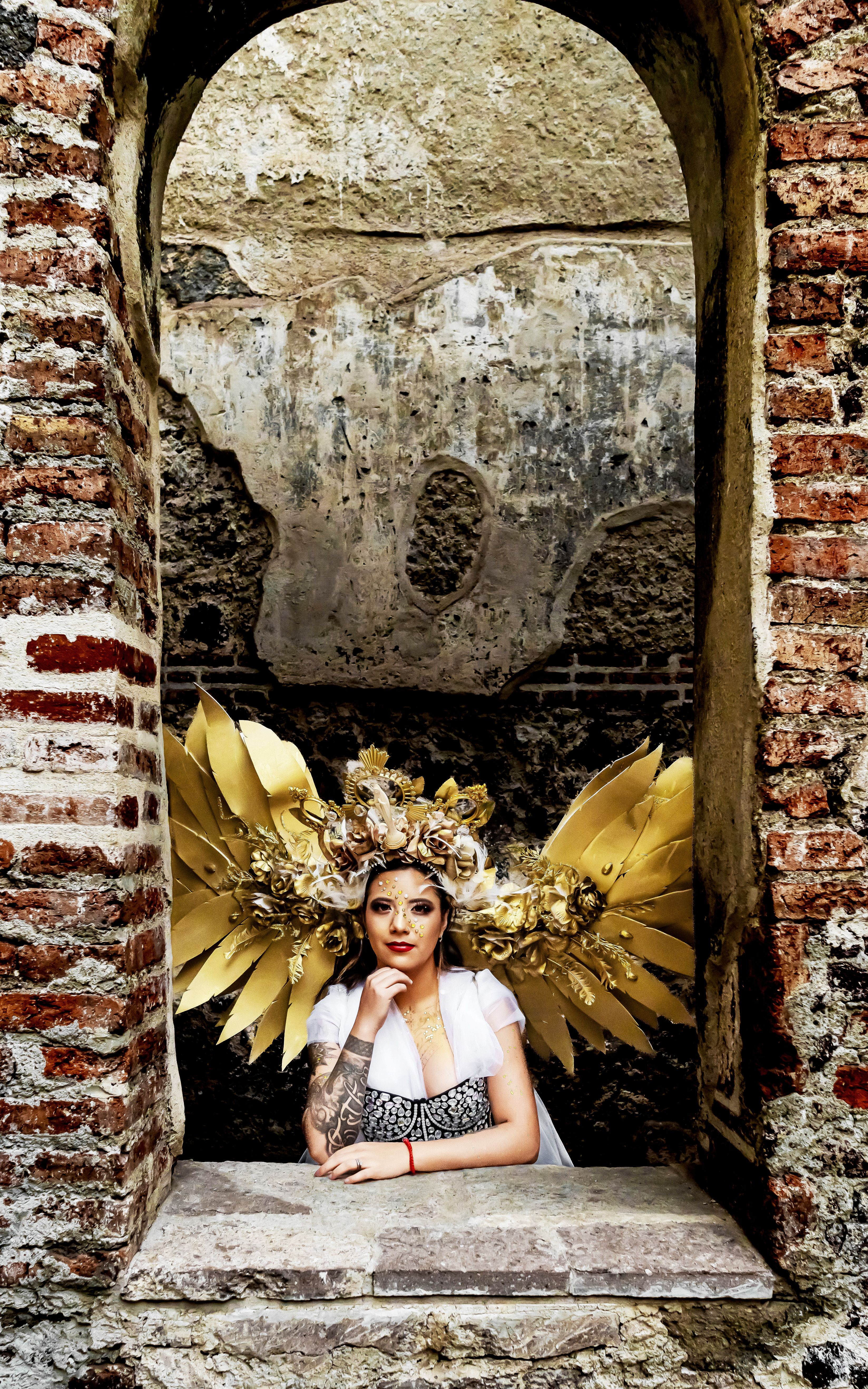 Woman with Golden Angel Wings in Window Opening · Free Stock Photo