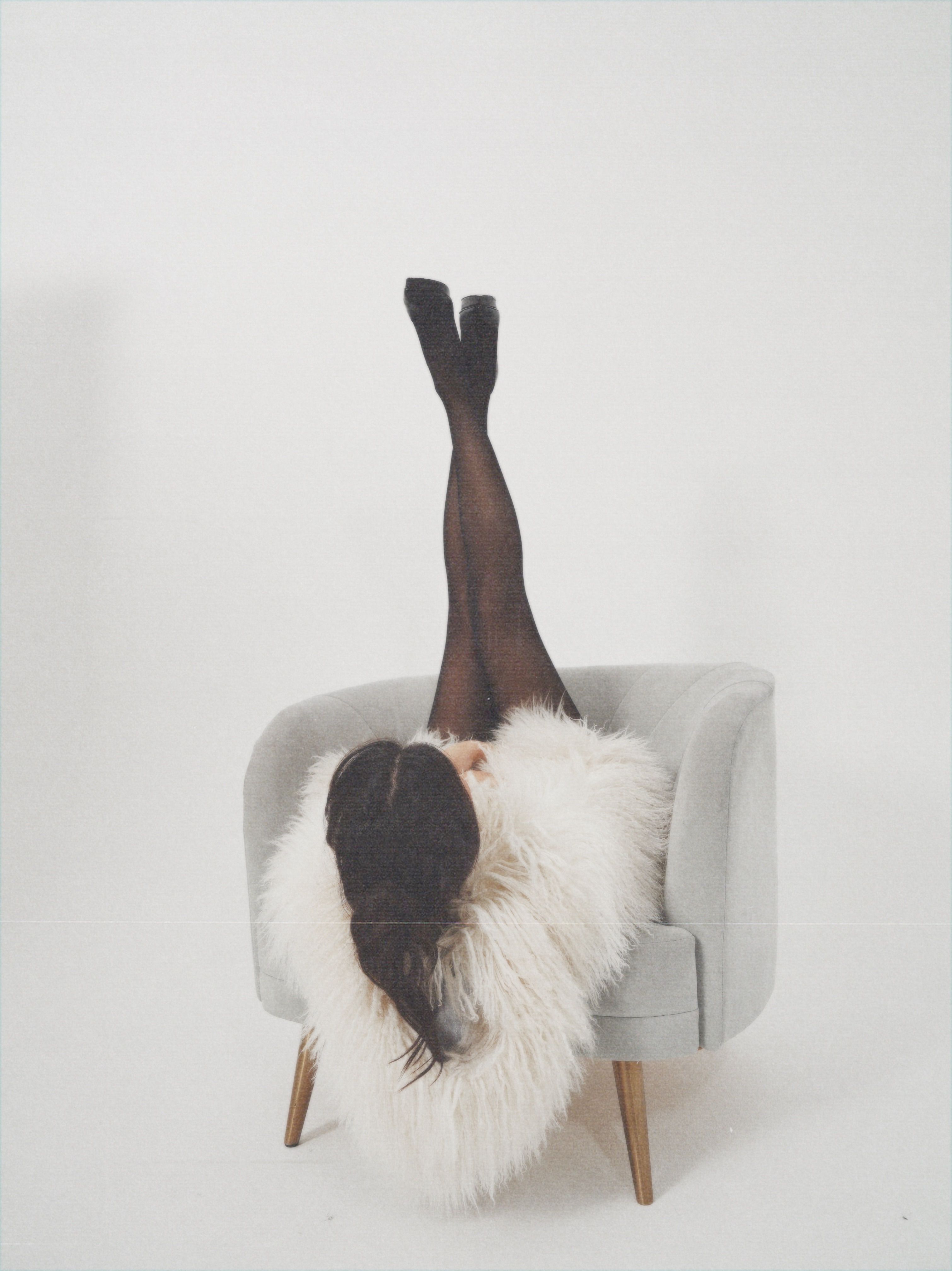 Studio Shot of a Model Lying on a Chair with Legs Up · Free Stock Photo