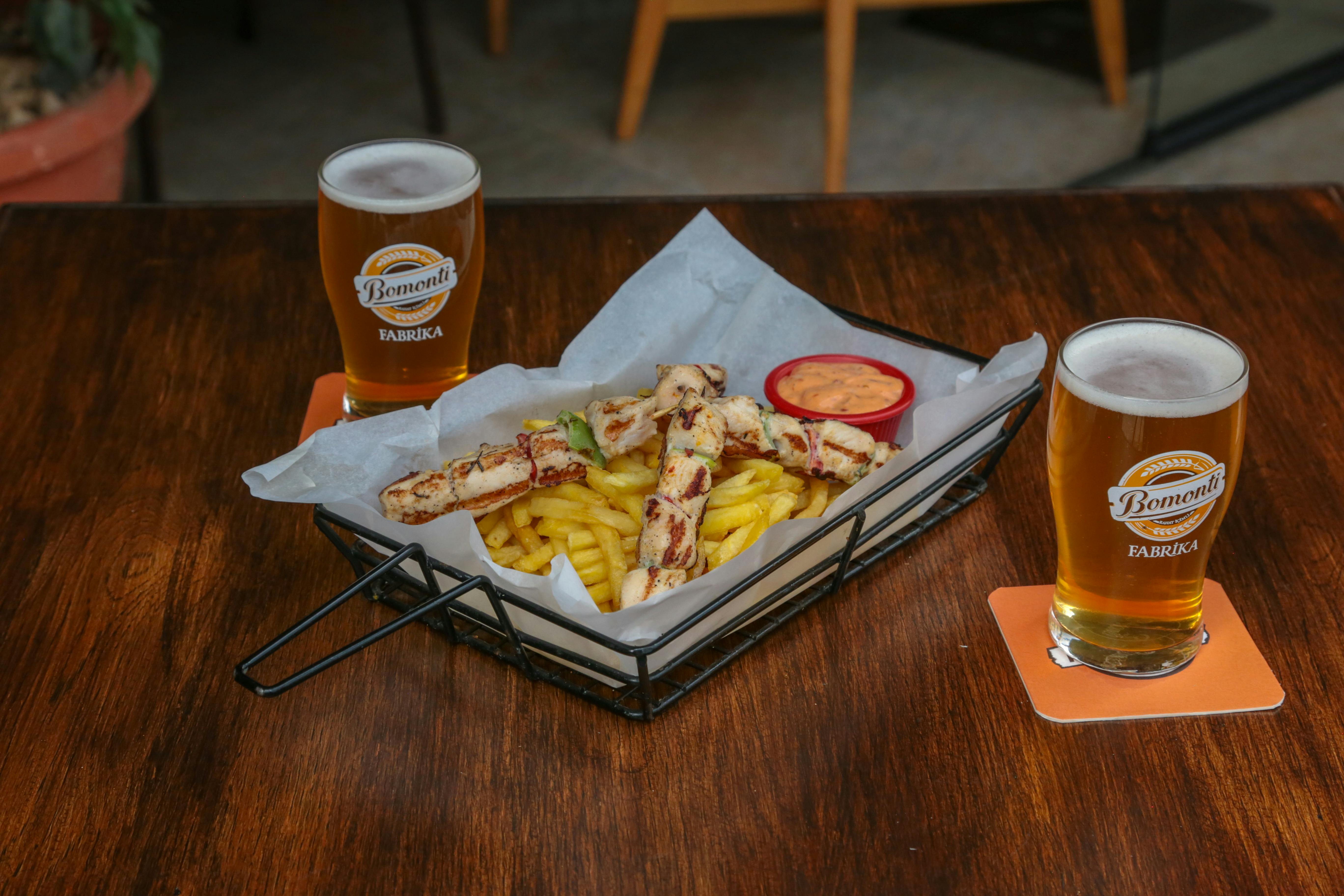A Meal with Two Beers Served on a Table in a Restaurant · Free Stock Photo