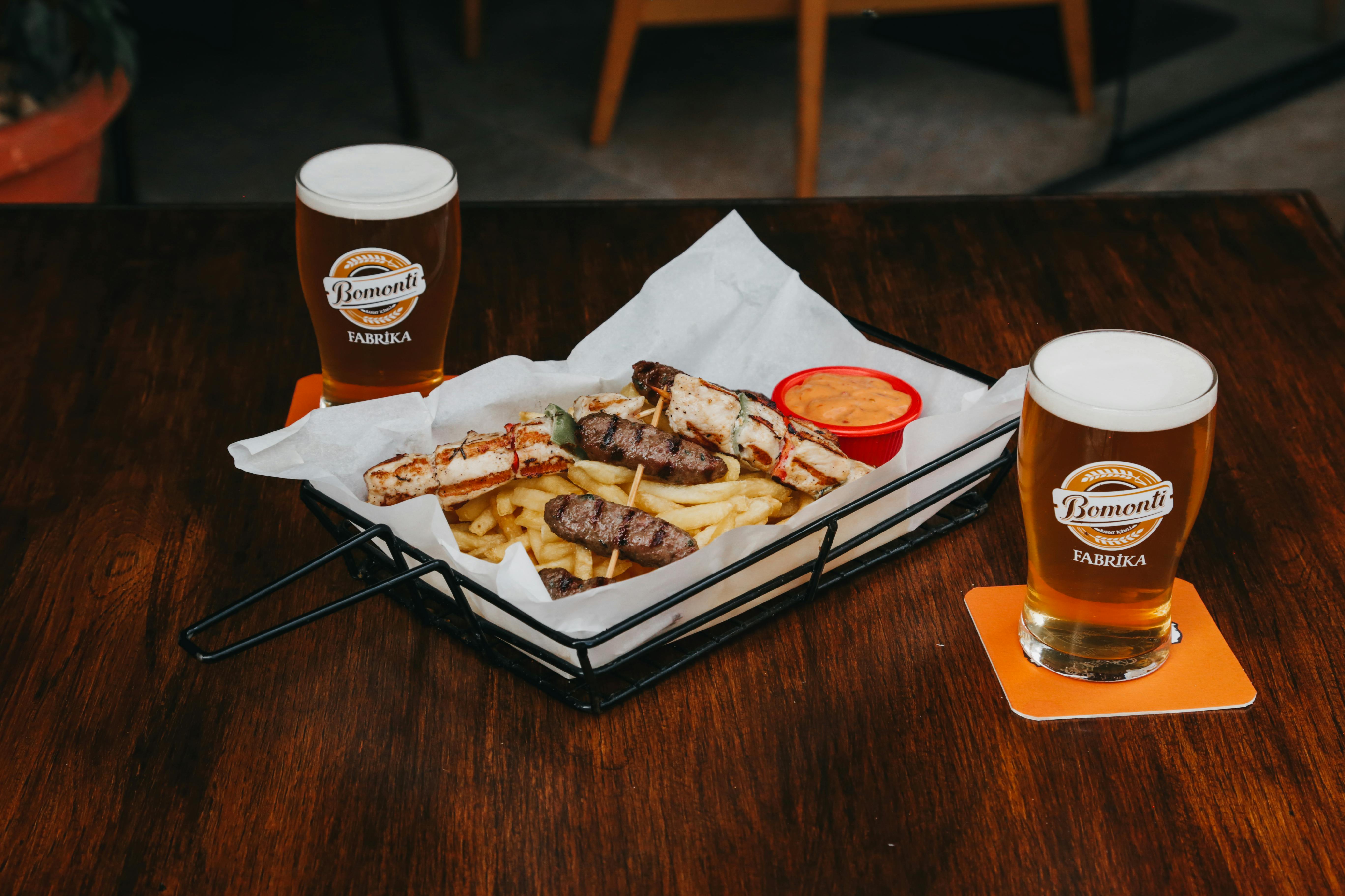 A tray with two beers and a plate of food · Free Stock Photo