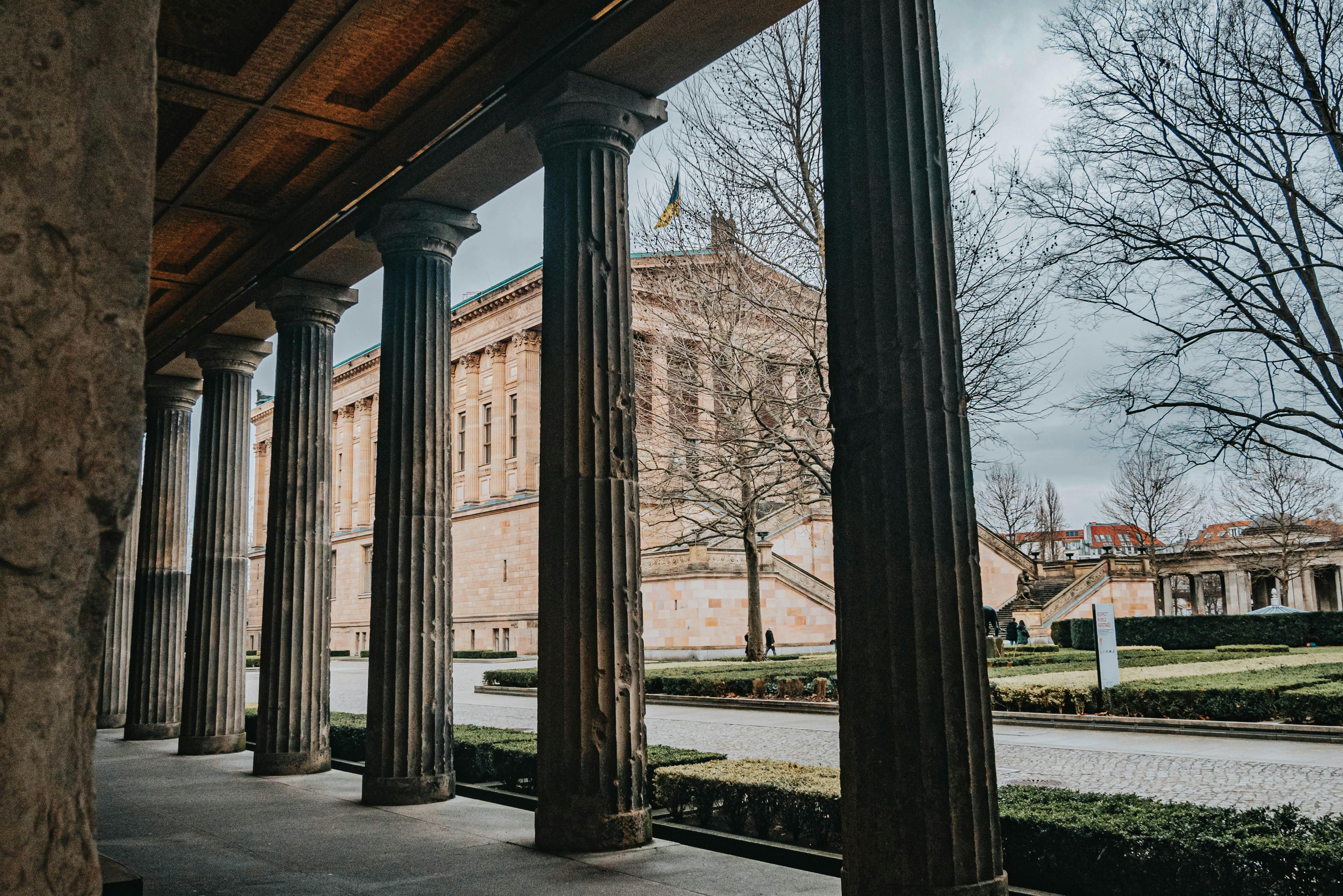 Passersby Between the Colonnades of the Arcade · Free Stock Photo