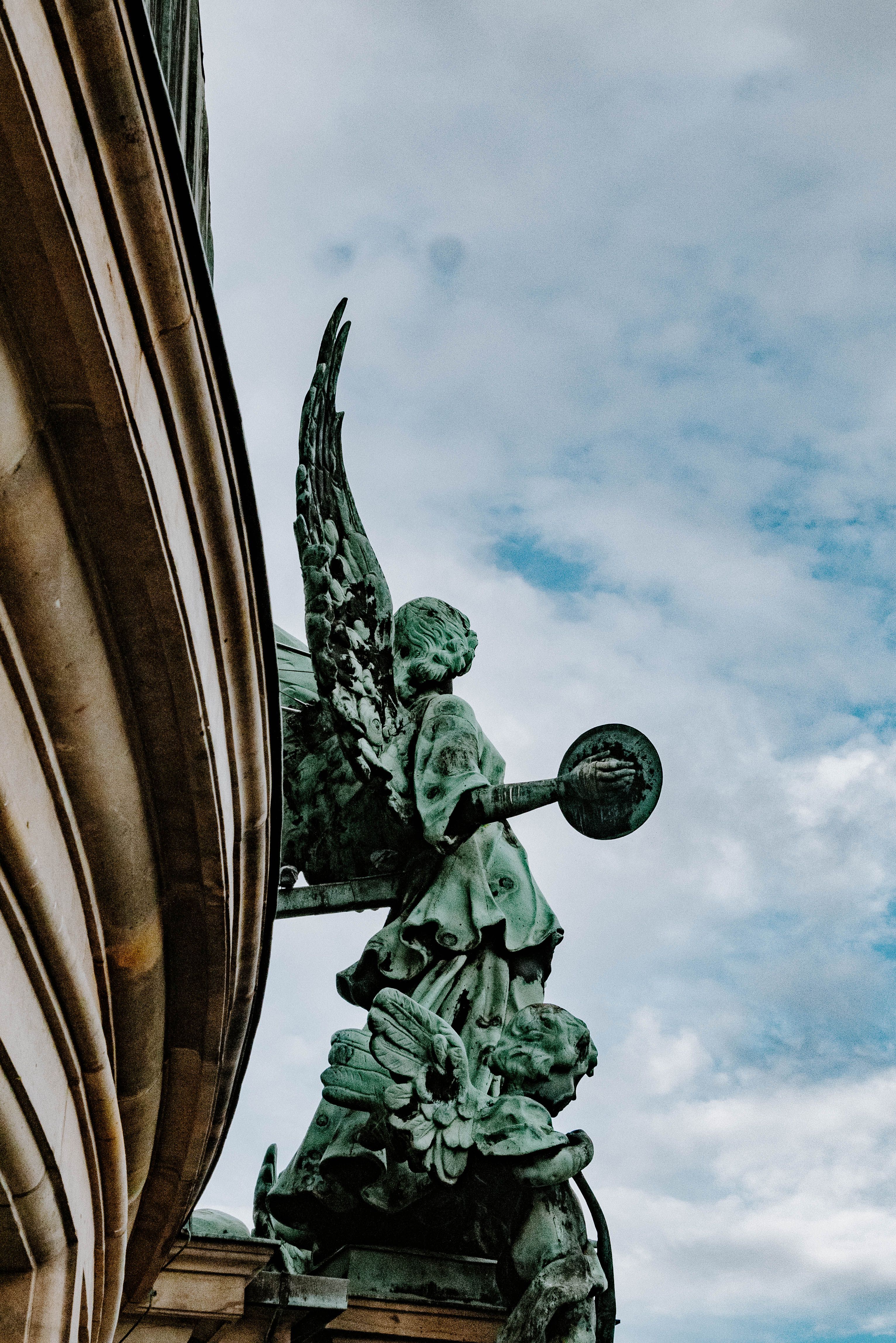 A statue of an angel on top of a building · Free Stock Photo