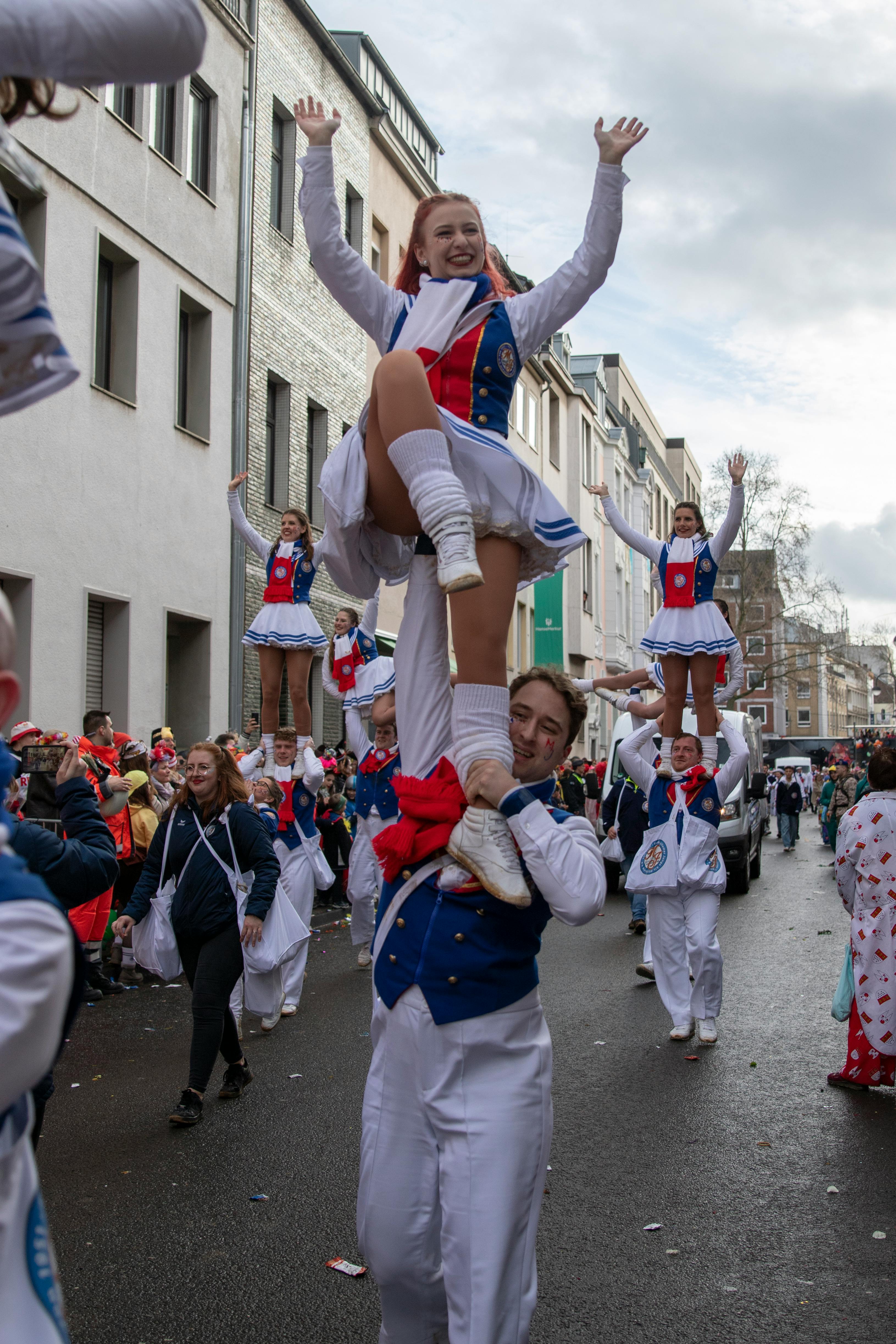 A group of people in costumes are performing in a parade · Free Stock Photo