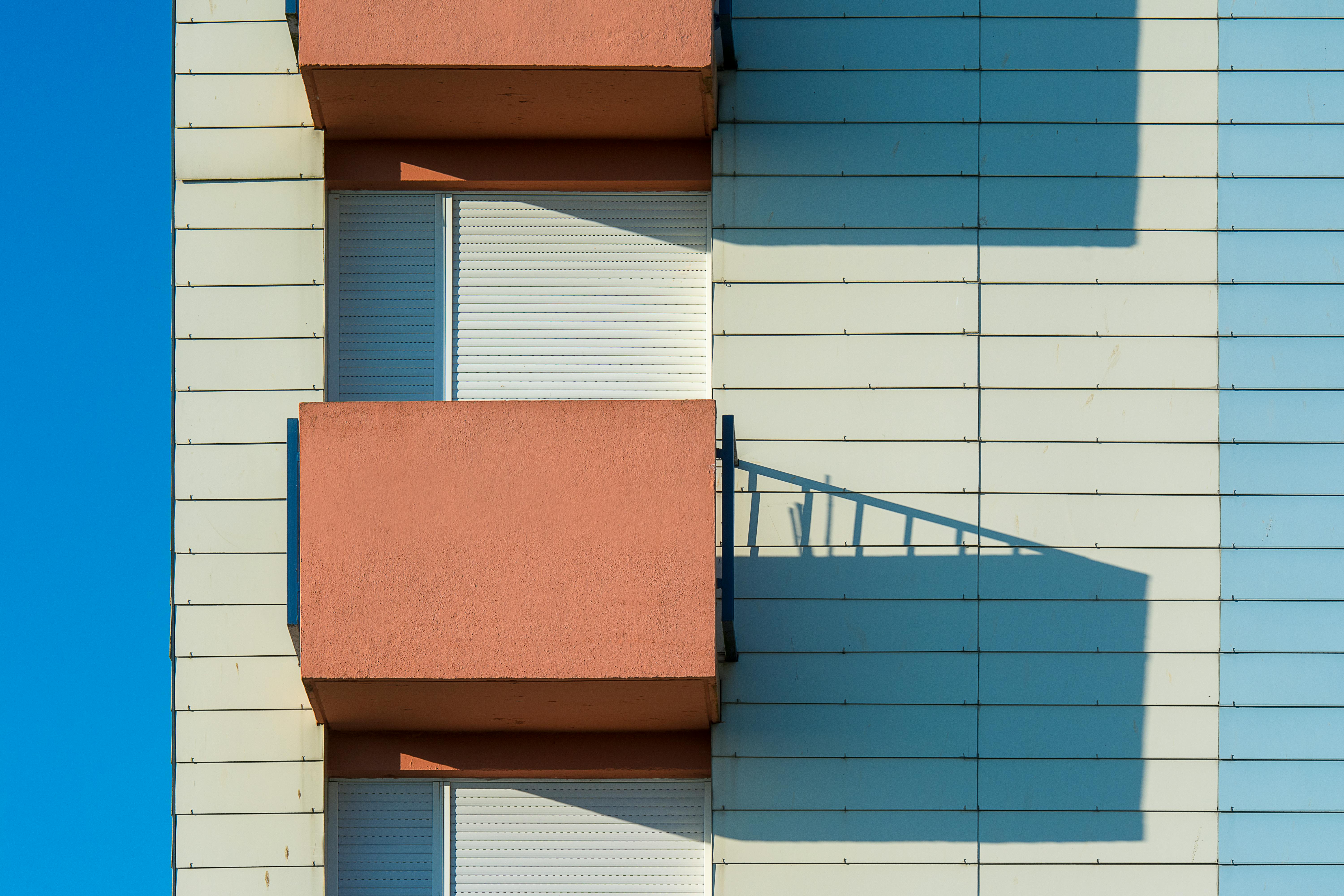 Red Balcony Casting Shadow on Wall · Free Stock Photo