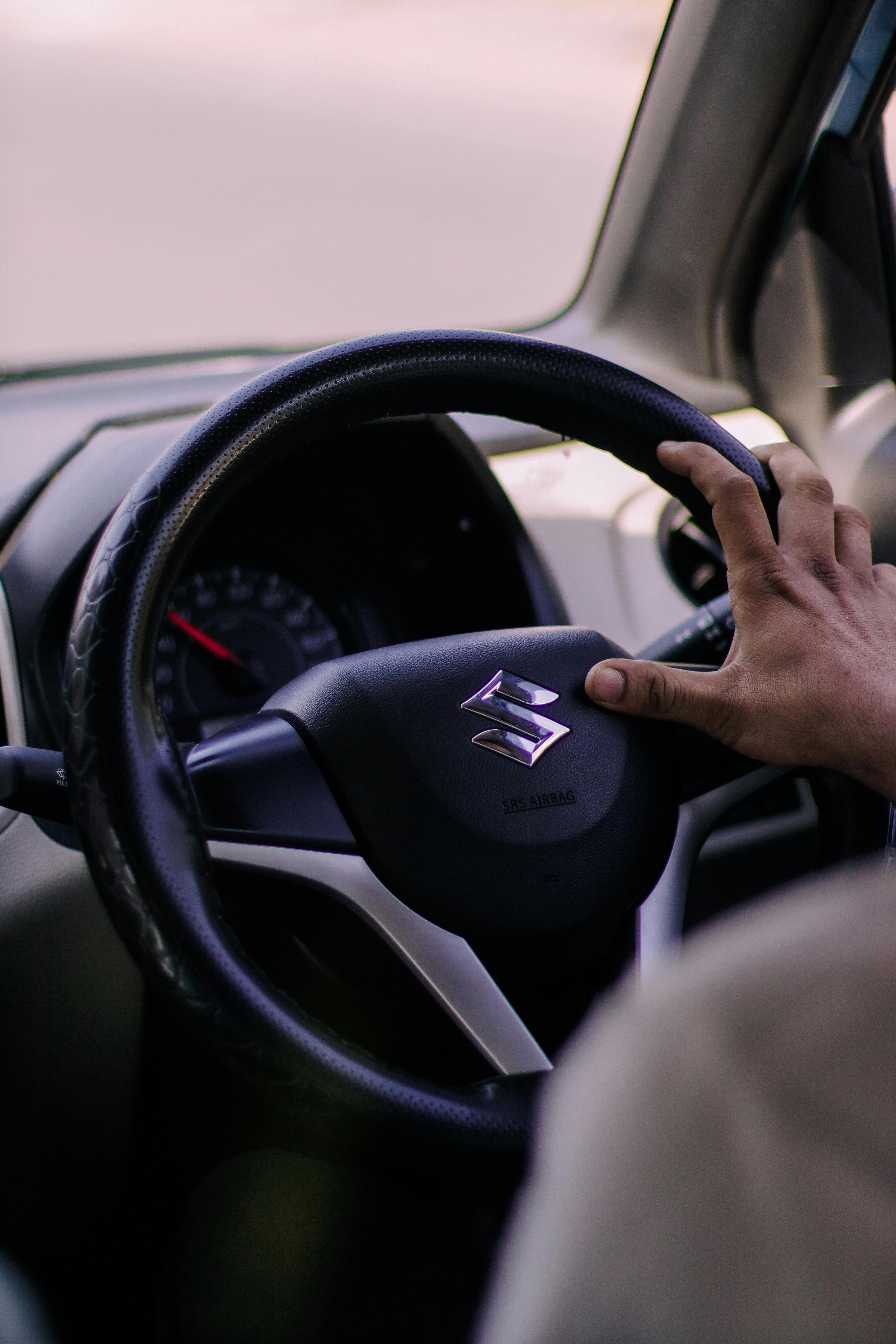 Close-up of a Person Sitting behind the Wheel of a Suzuki Car · Free ...