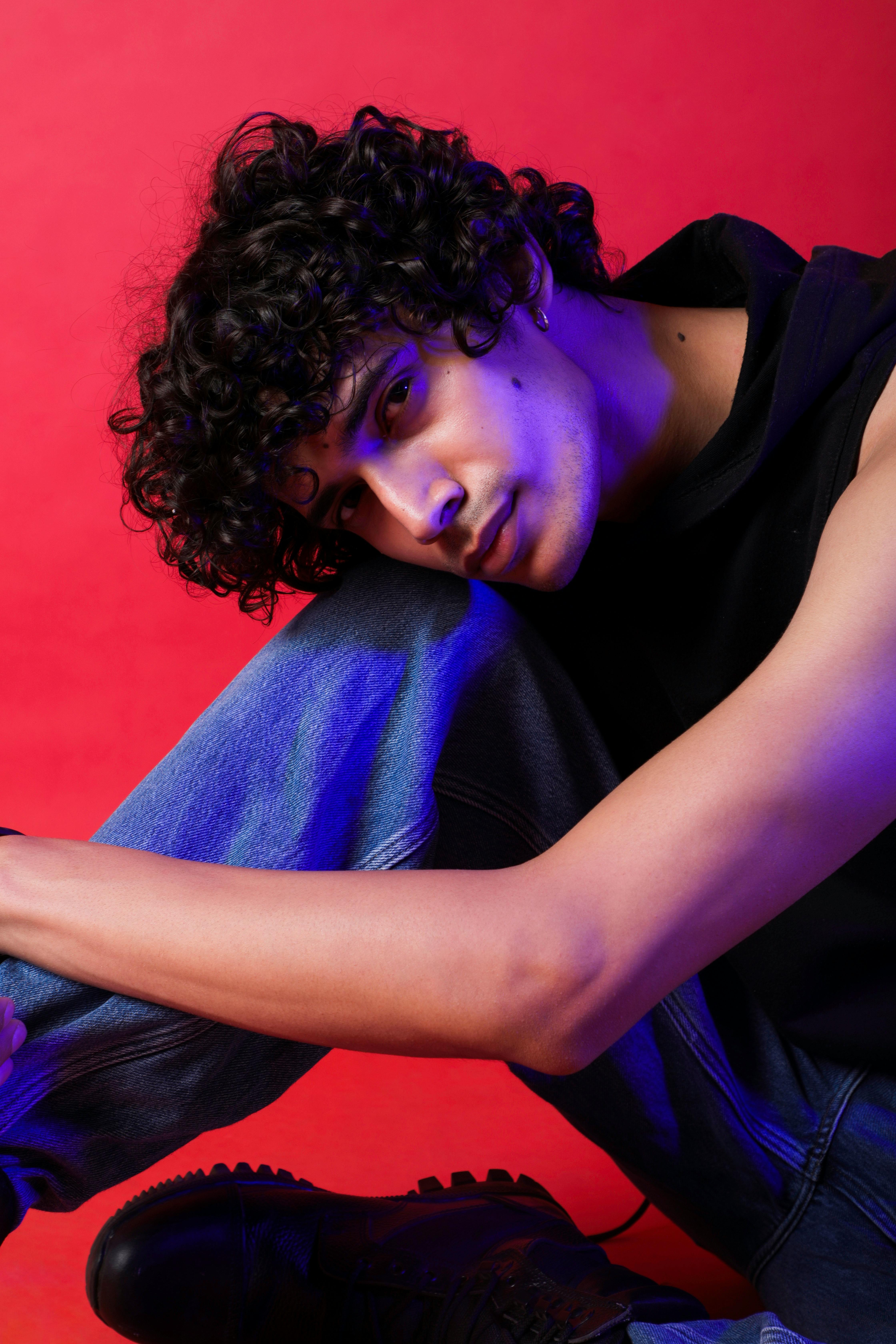 Portrait of Man Sitting on Red Background · Free Stock Photo