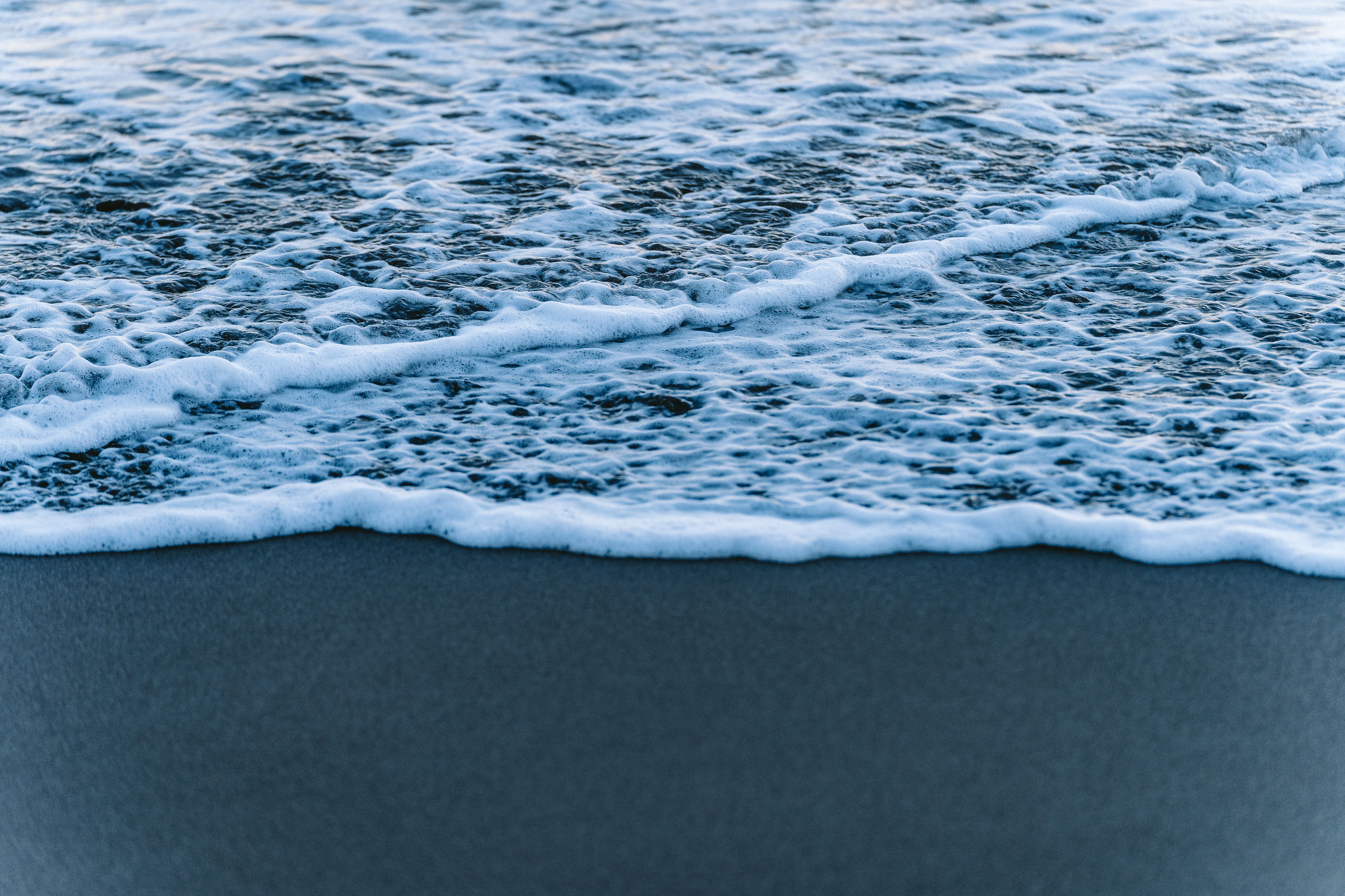 Close-up of a Foamy Wave Washing Up the Beach · Free Stock Photo