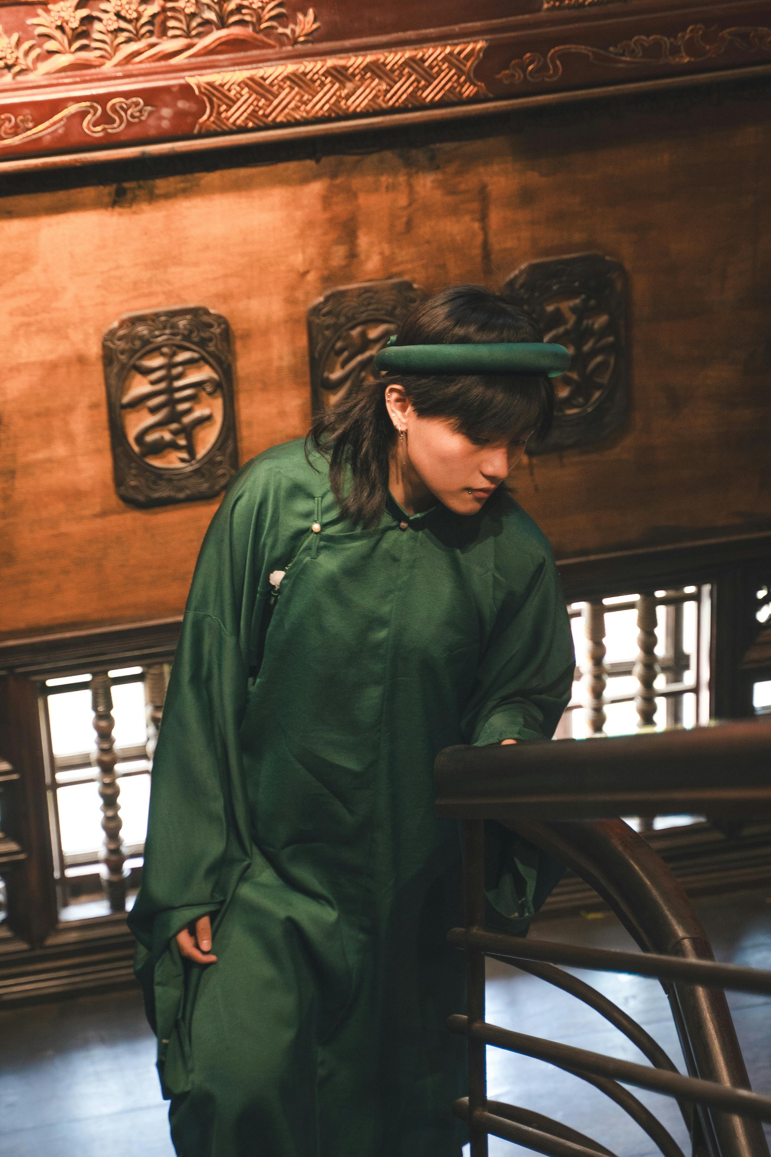 Woman Standing in Green, Traditional Clothing on Stairs · Free Stock Photo