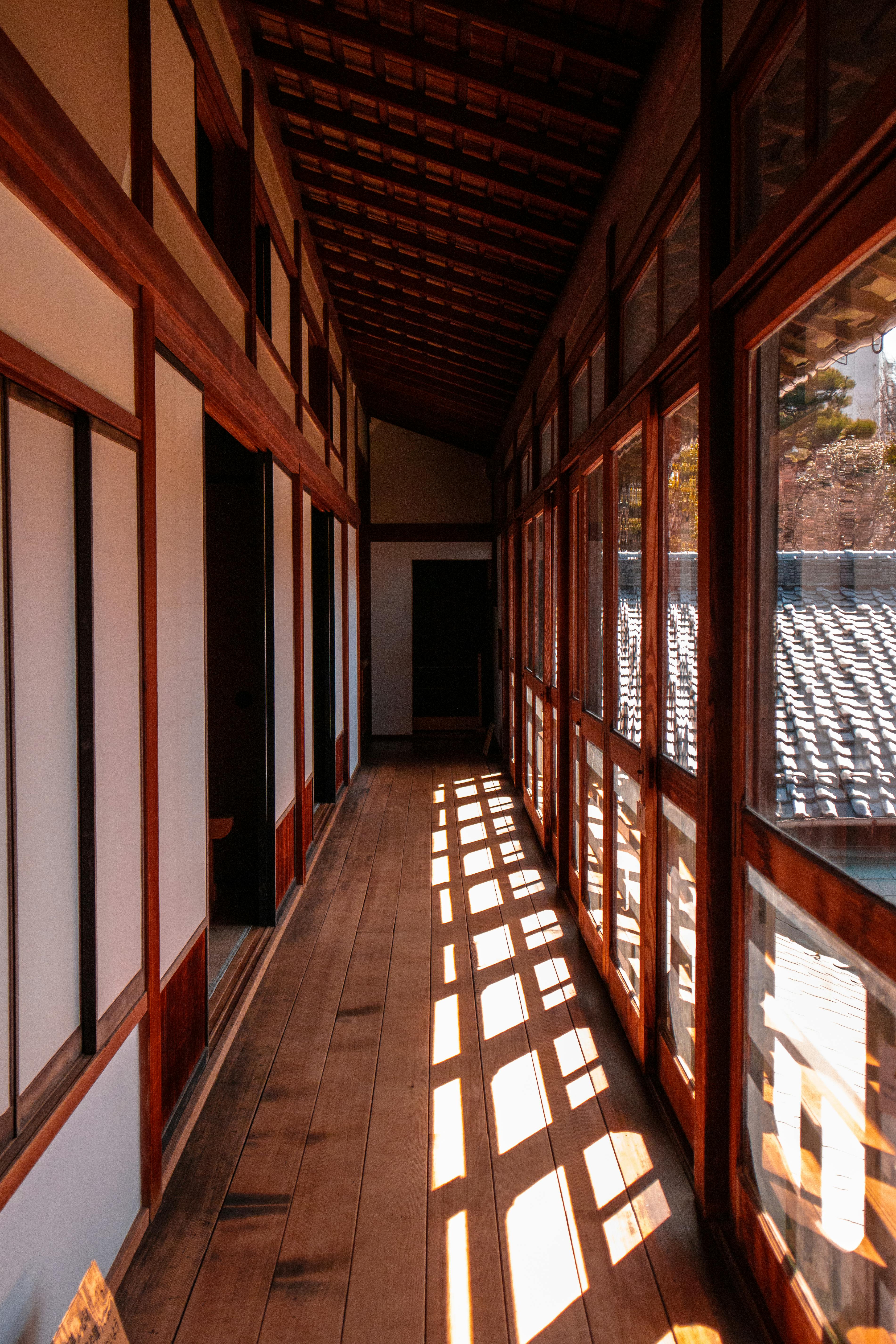 View of a Hallway with Wooden Floor and Wall of Windows · Free Stock Photo