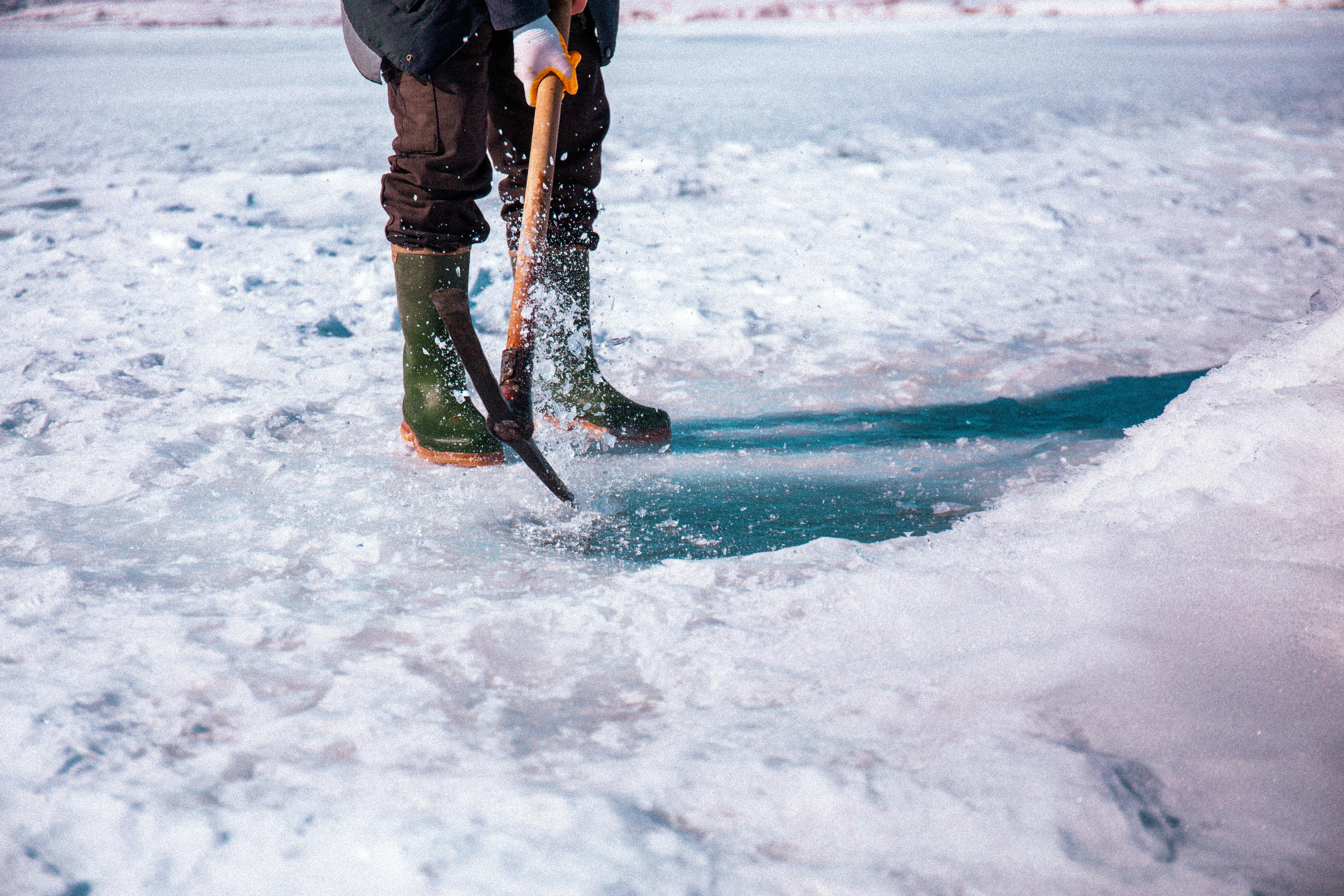 Close-up of a Man Breaking the Ice on a Frozen Lake · Free Stock Photo