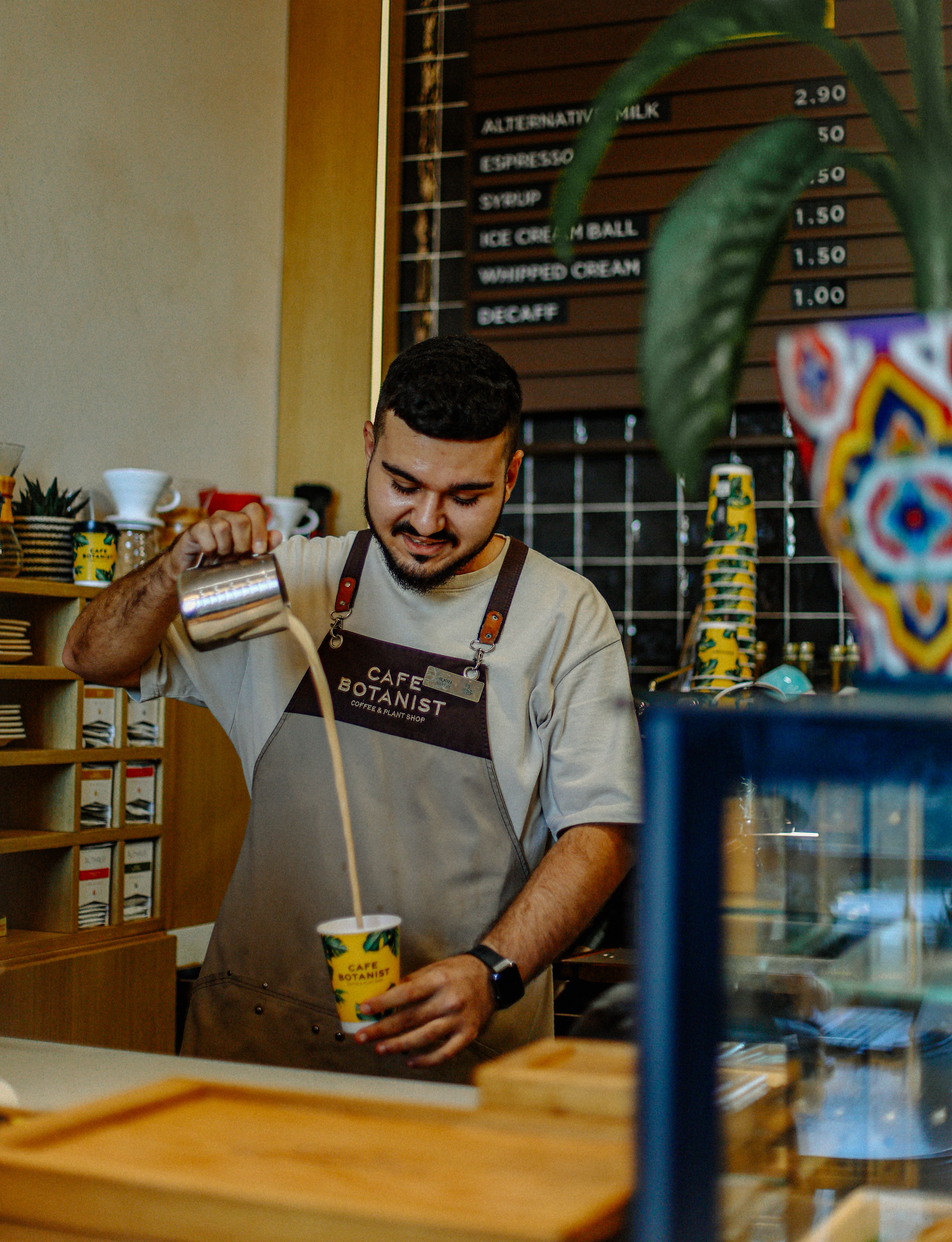 Smiling Man Pouring Coffee at Cafe · Free Stock Photo