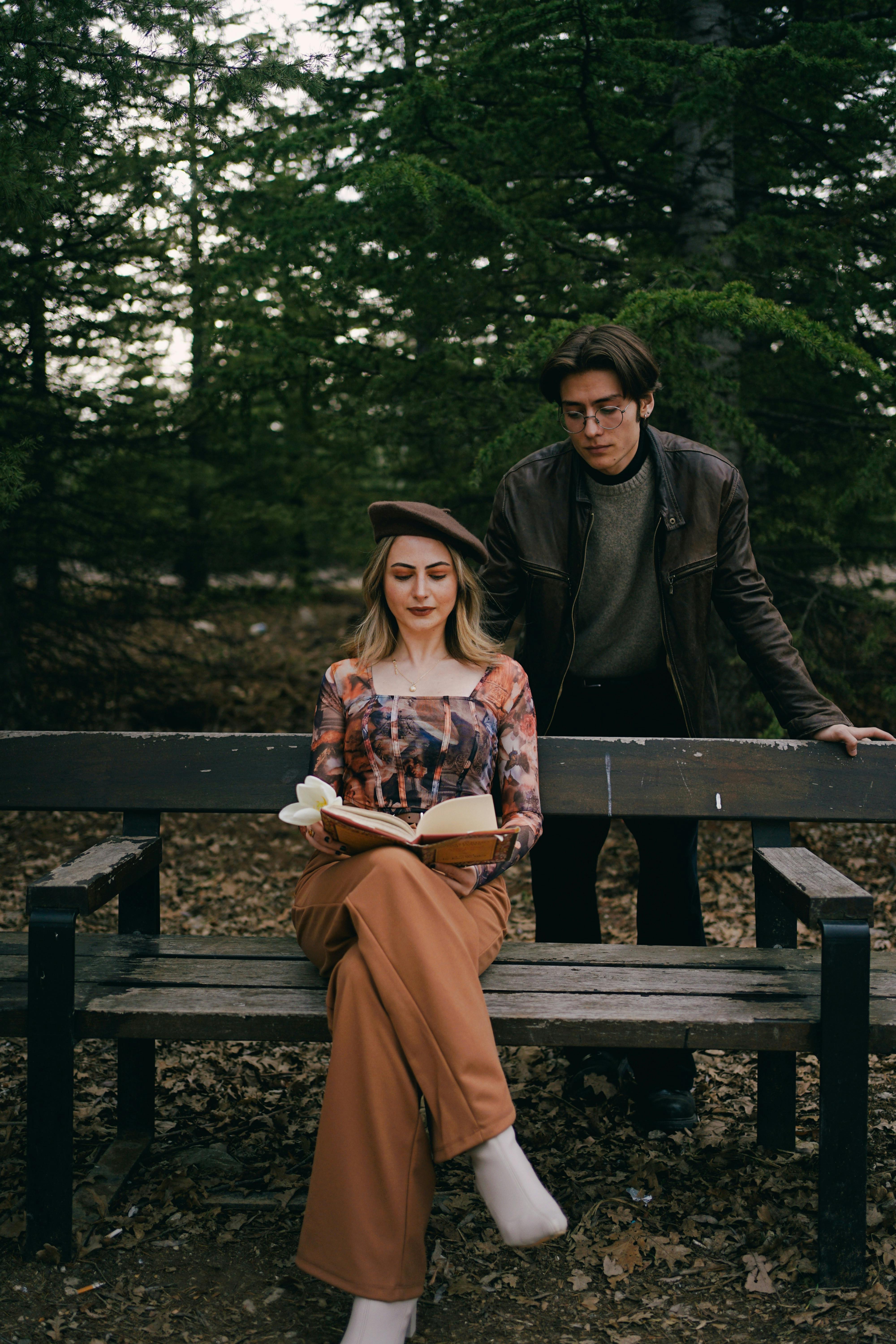 Man Looking over Womans Shoulder at Book in her Hands · Free Stock Photo