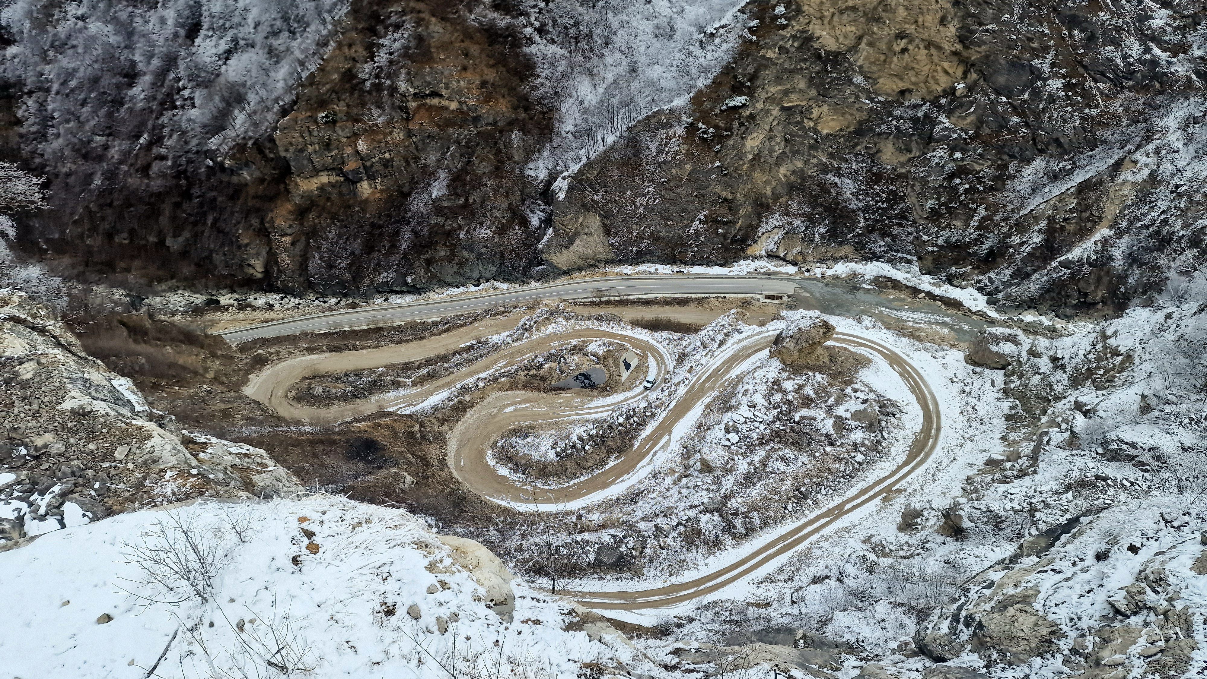 A mountain road with a winding path in the snow · Free Stock Photo