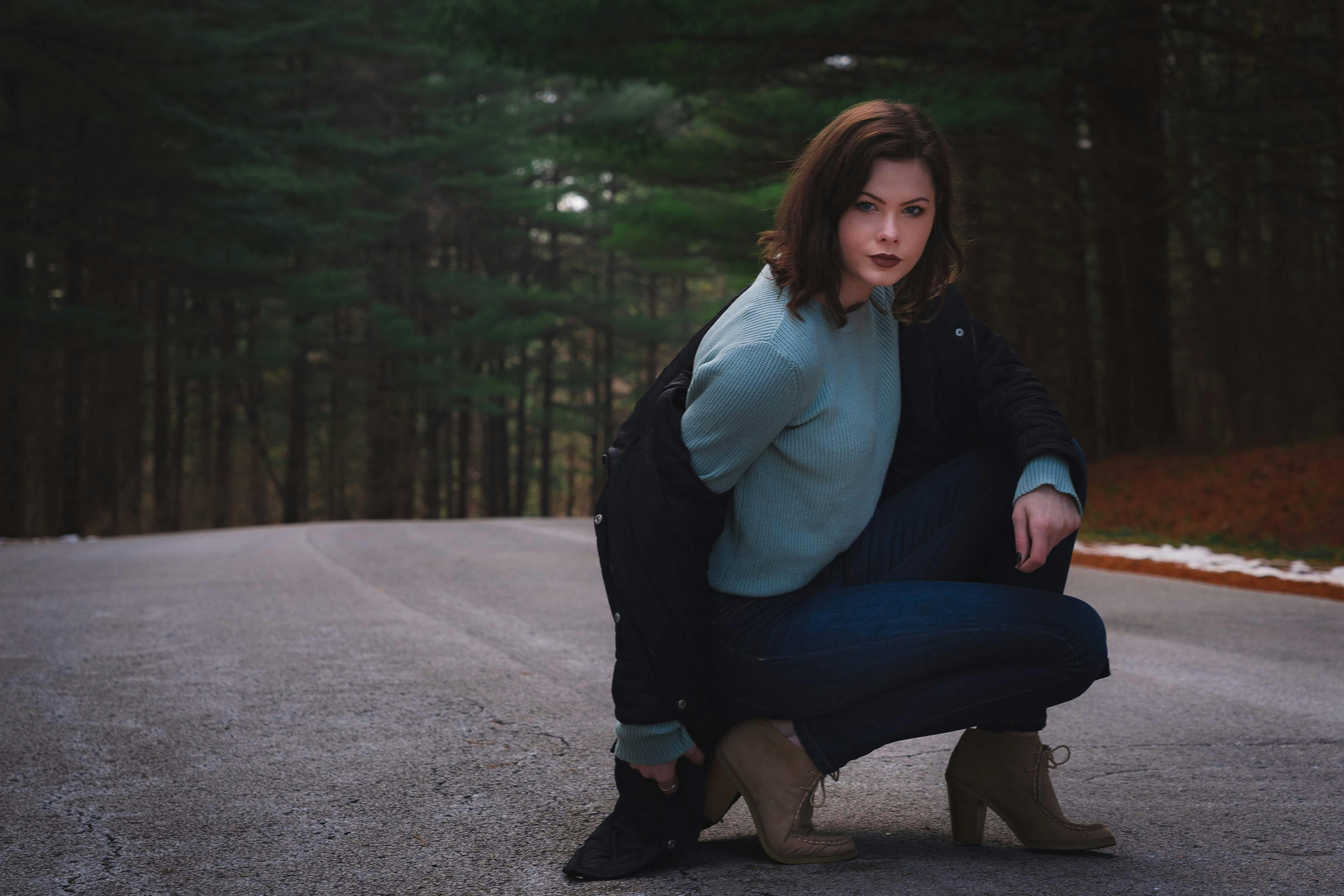 Woman Squatting on Road in Forest · Free Stock Photo