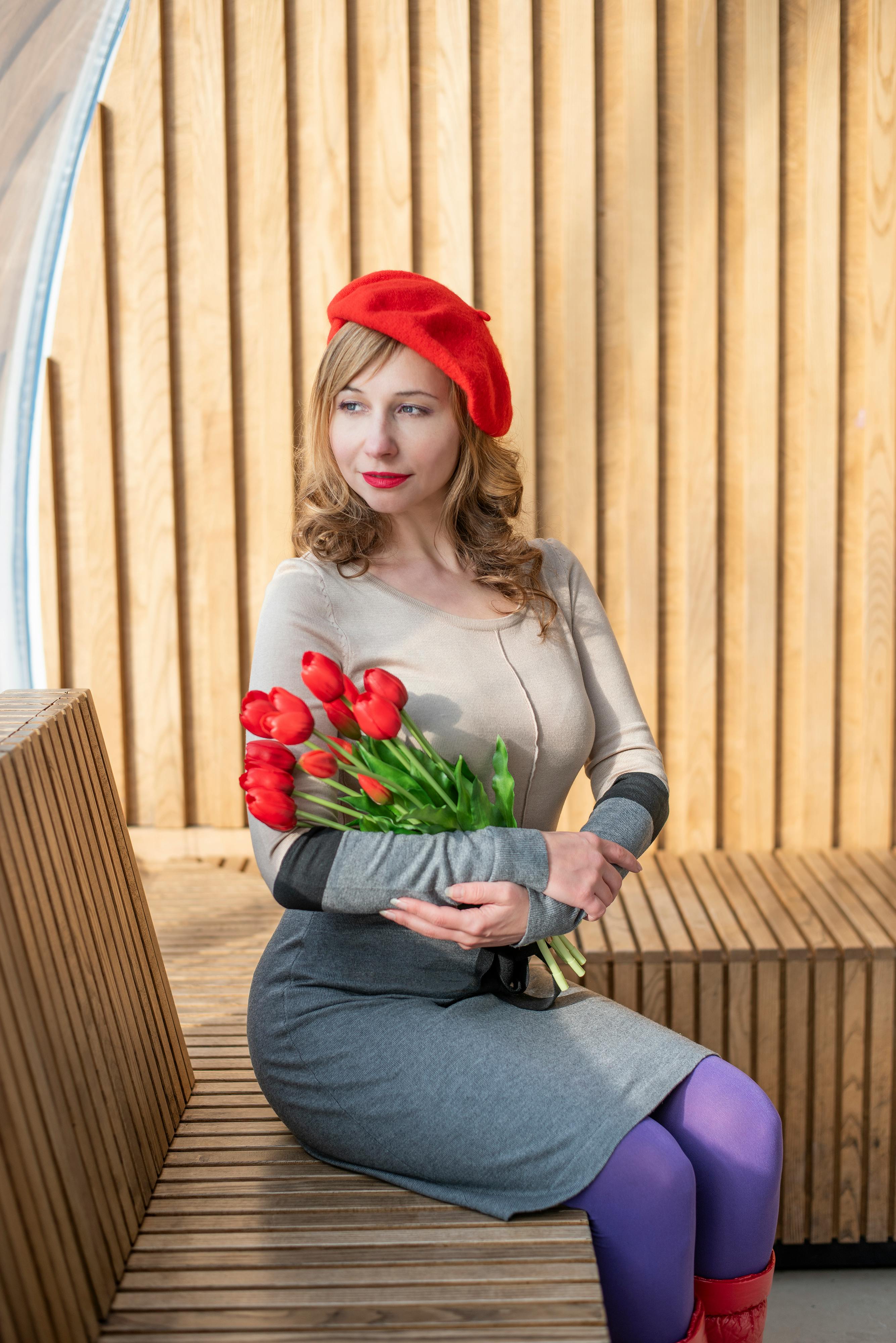 Elegant Woman Sitting on a Bench and Holding a Bunch of Flowers · Free ...
