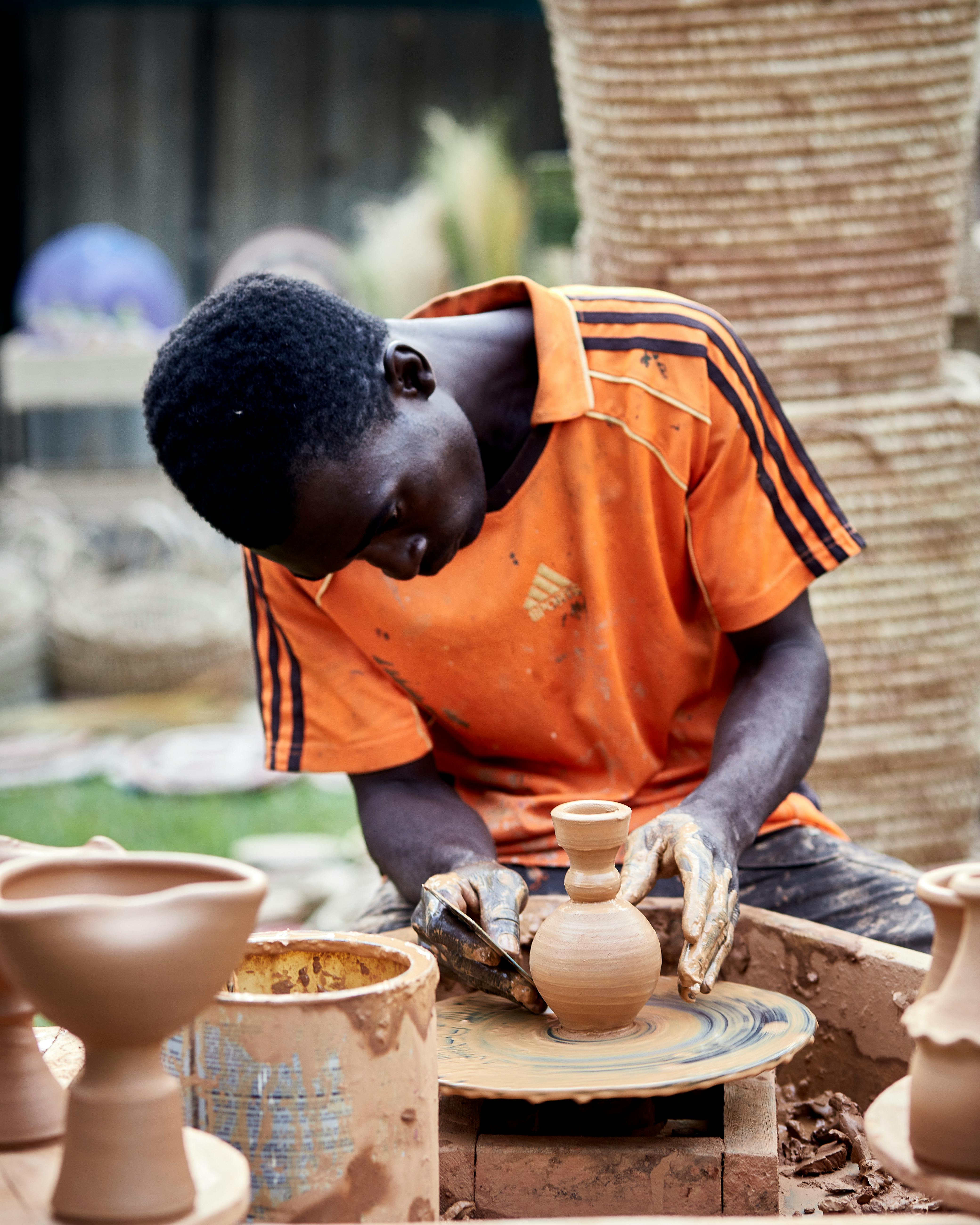 A young man is making clay pots in a workshop · Free Stock Photo