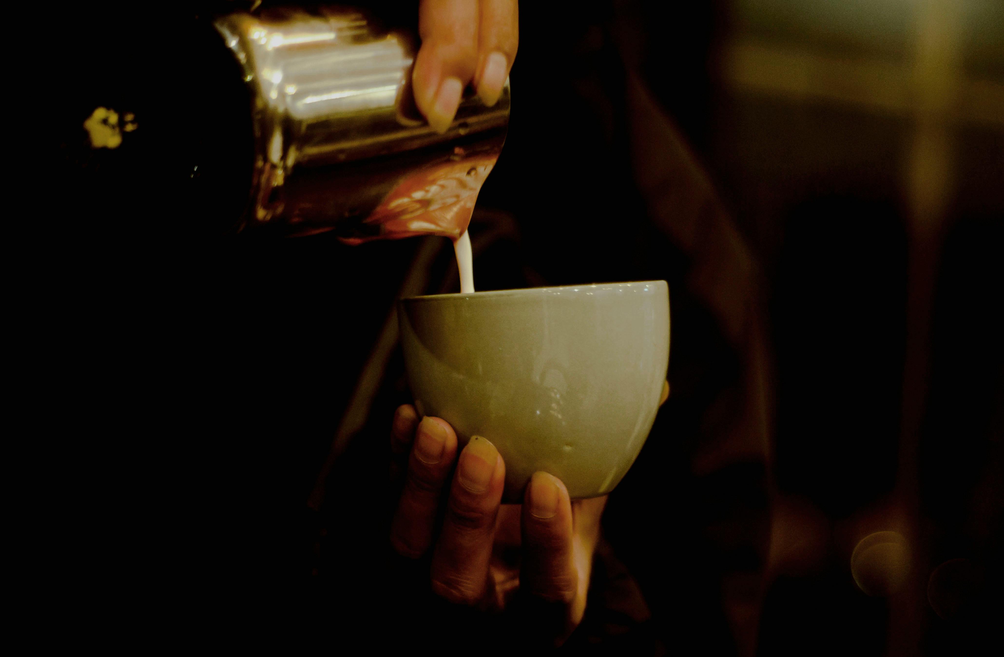 Person Pouring Cream in Espresso · Free Stock Photo
