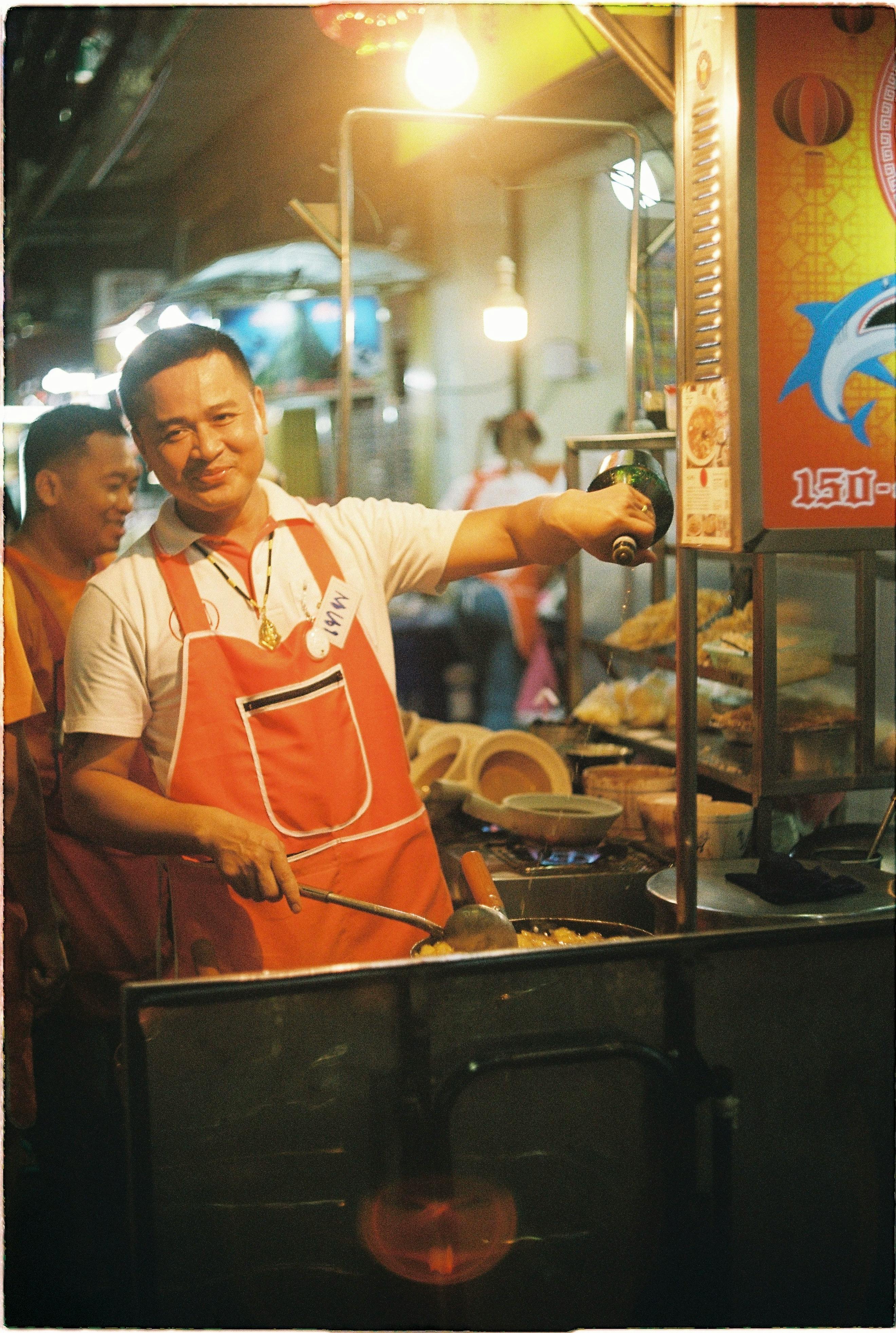 Man Working at Street Food Stand at Night · Free Stock Photo