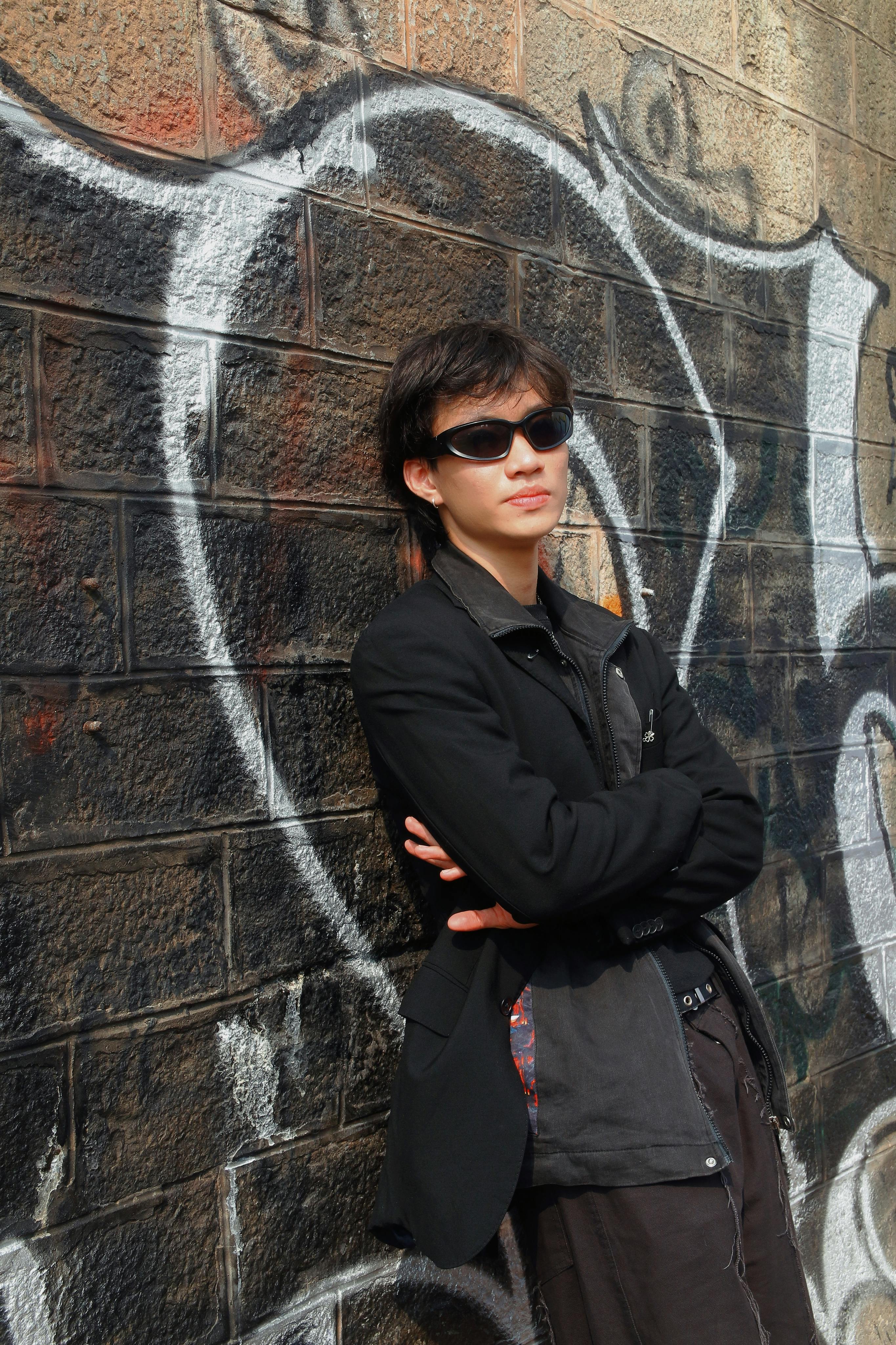 A Person in Sunglasses Against the Wall · Free Stock Photo