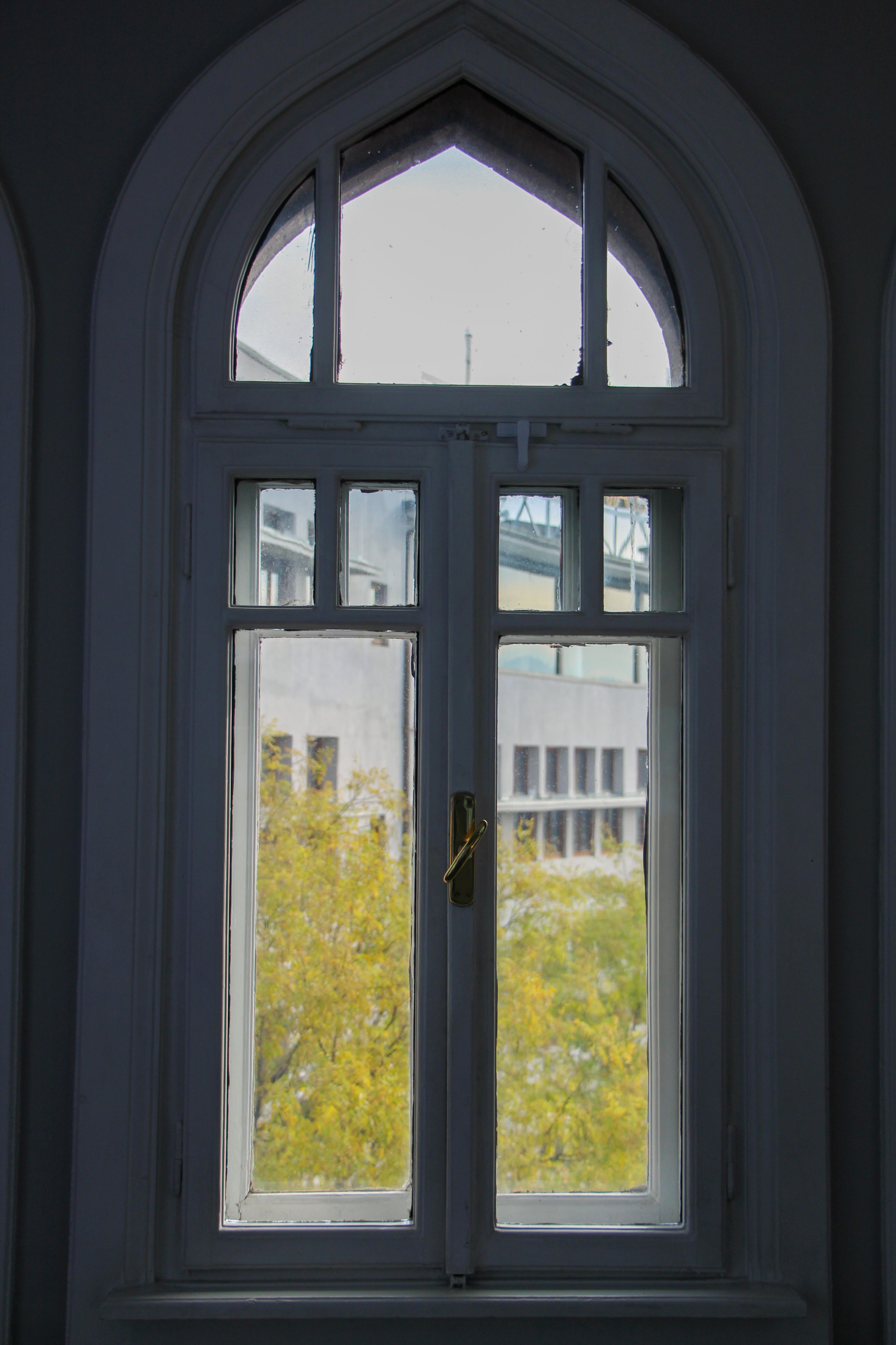 A window with a view of a building and trees · Free Stock Photo