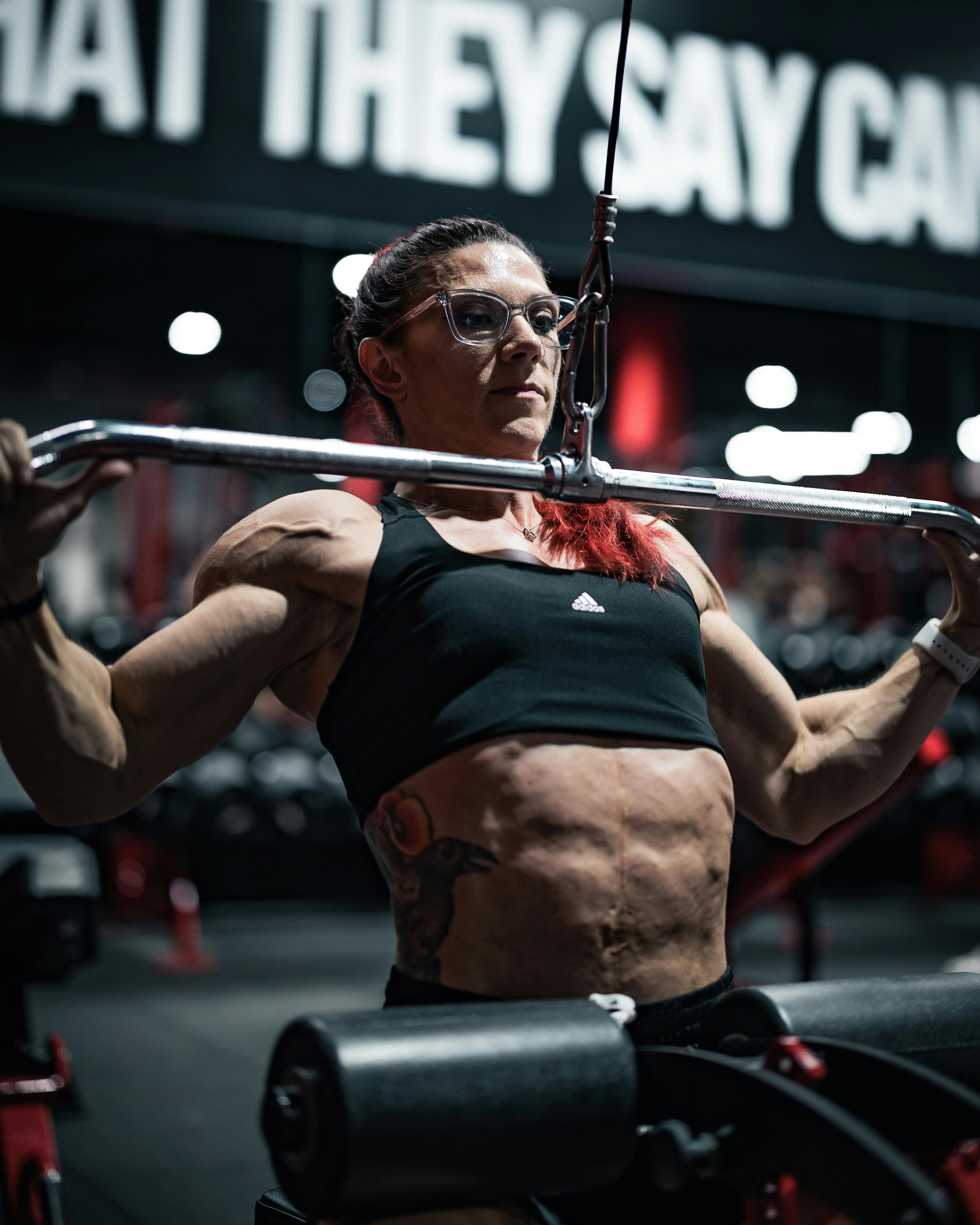 Muscular Woman Lifting Weights at Gym · Free Stock Photo