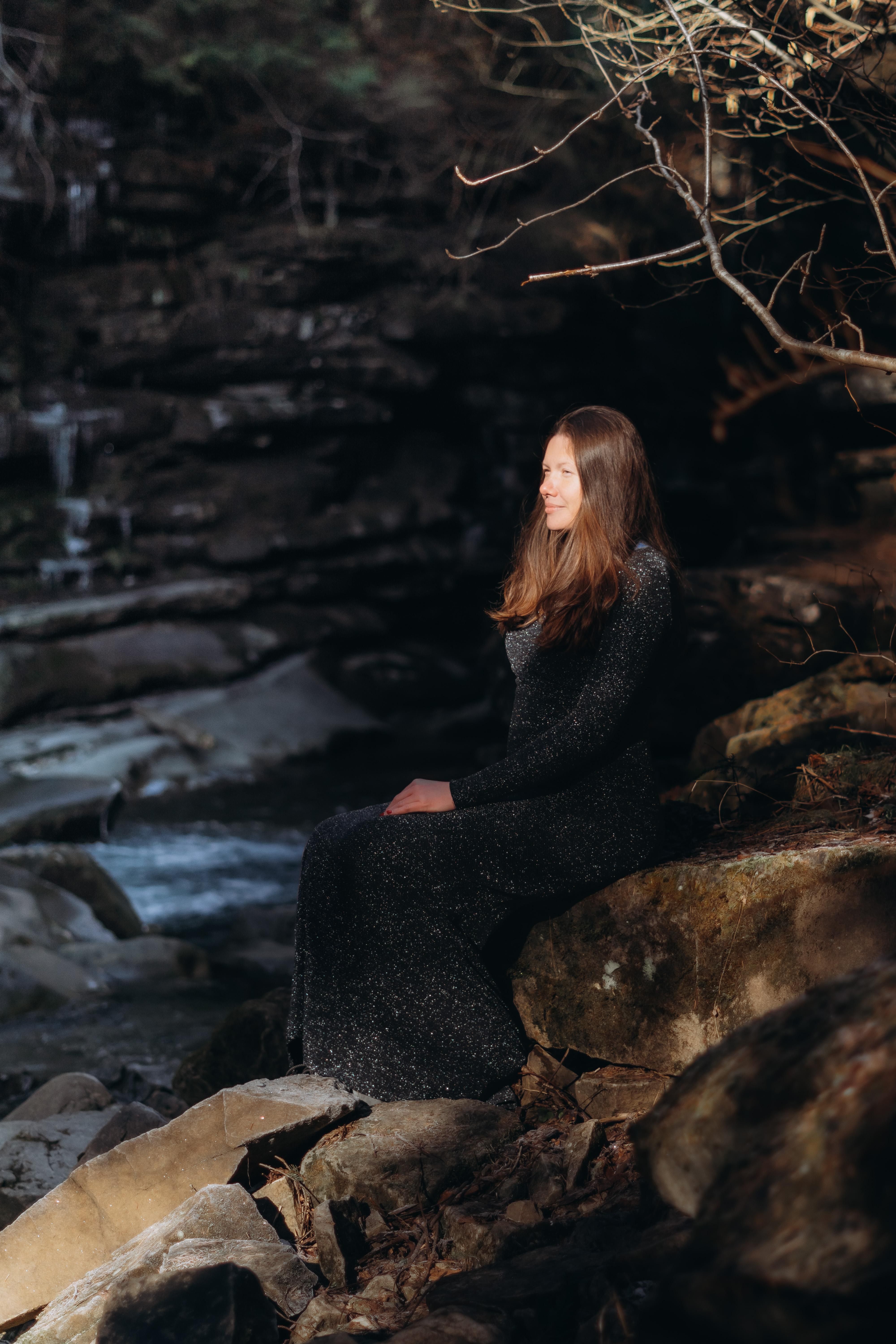 Woman in Black Dress Sitting by Stream · Free Stock Photo