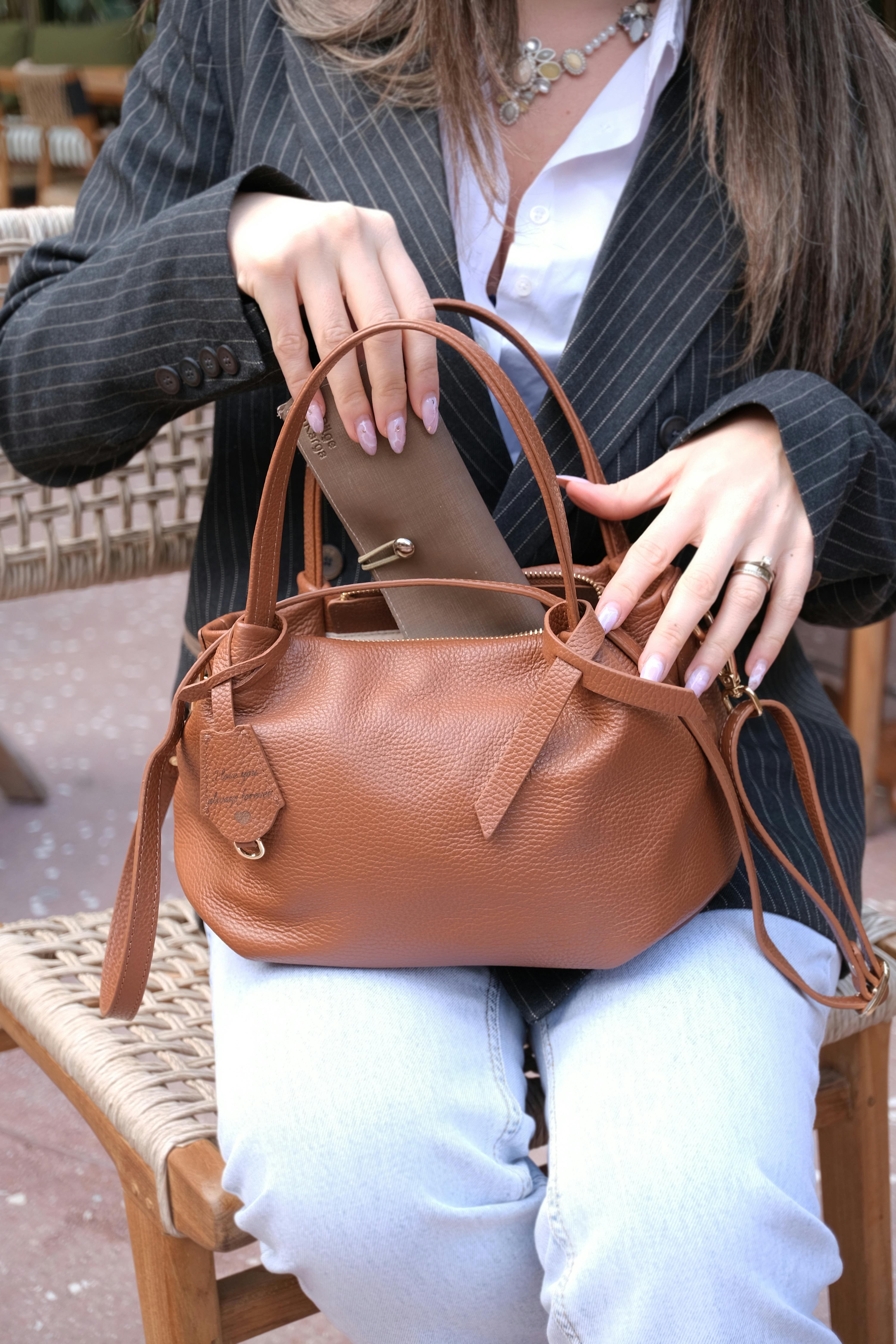 Woman reaching into Her Handbag Pulling Out Smaller Pouch · Free Stock ...