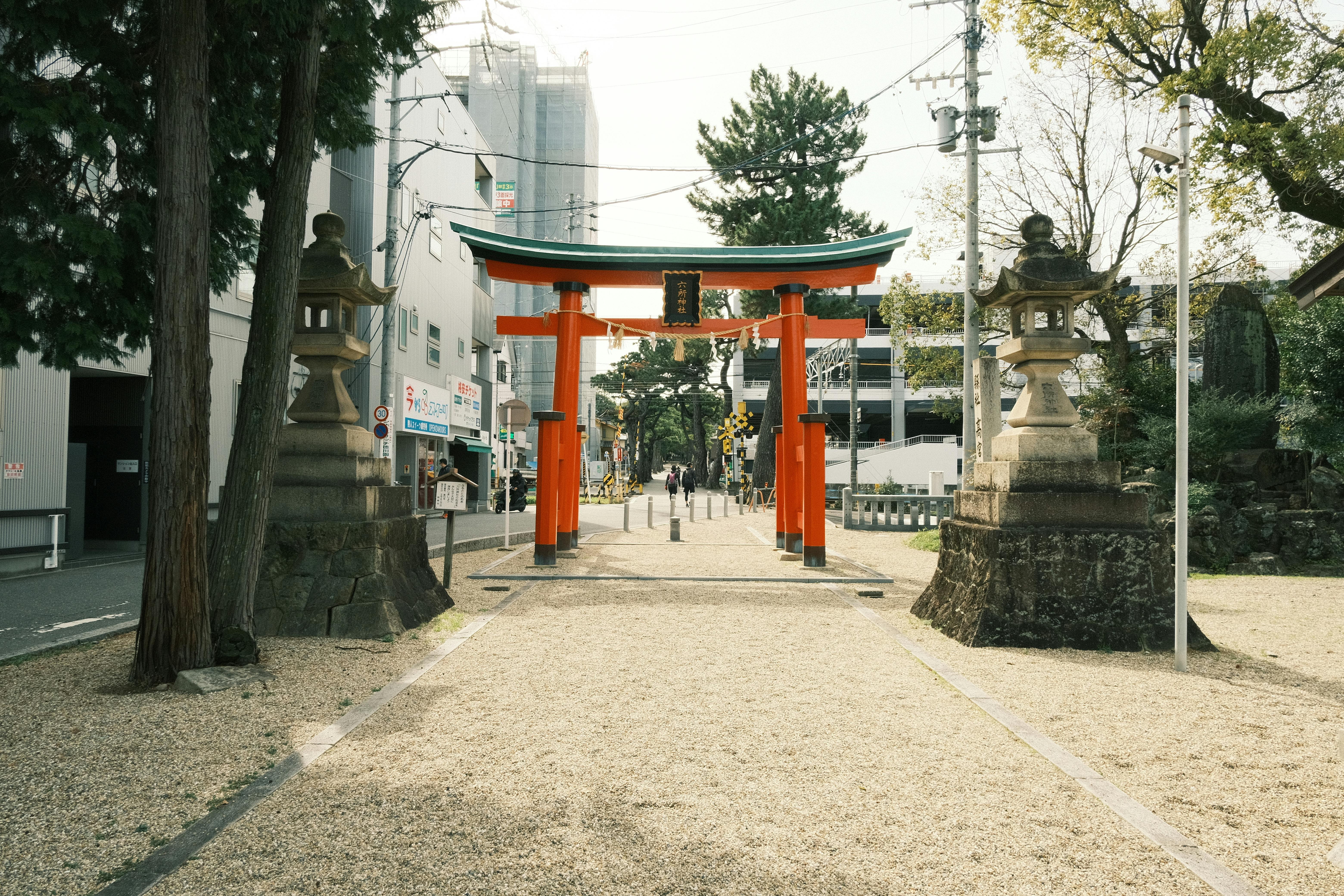 A red tori gate is in the middle of a walkway · Free Stock Photo
