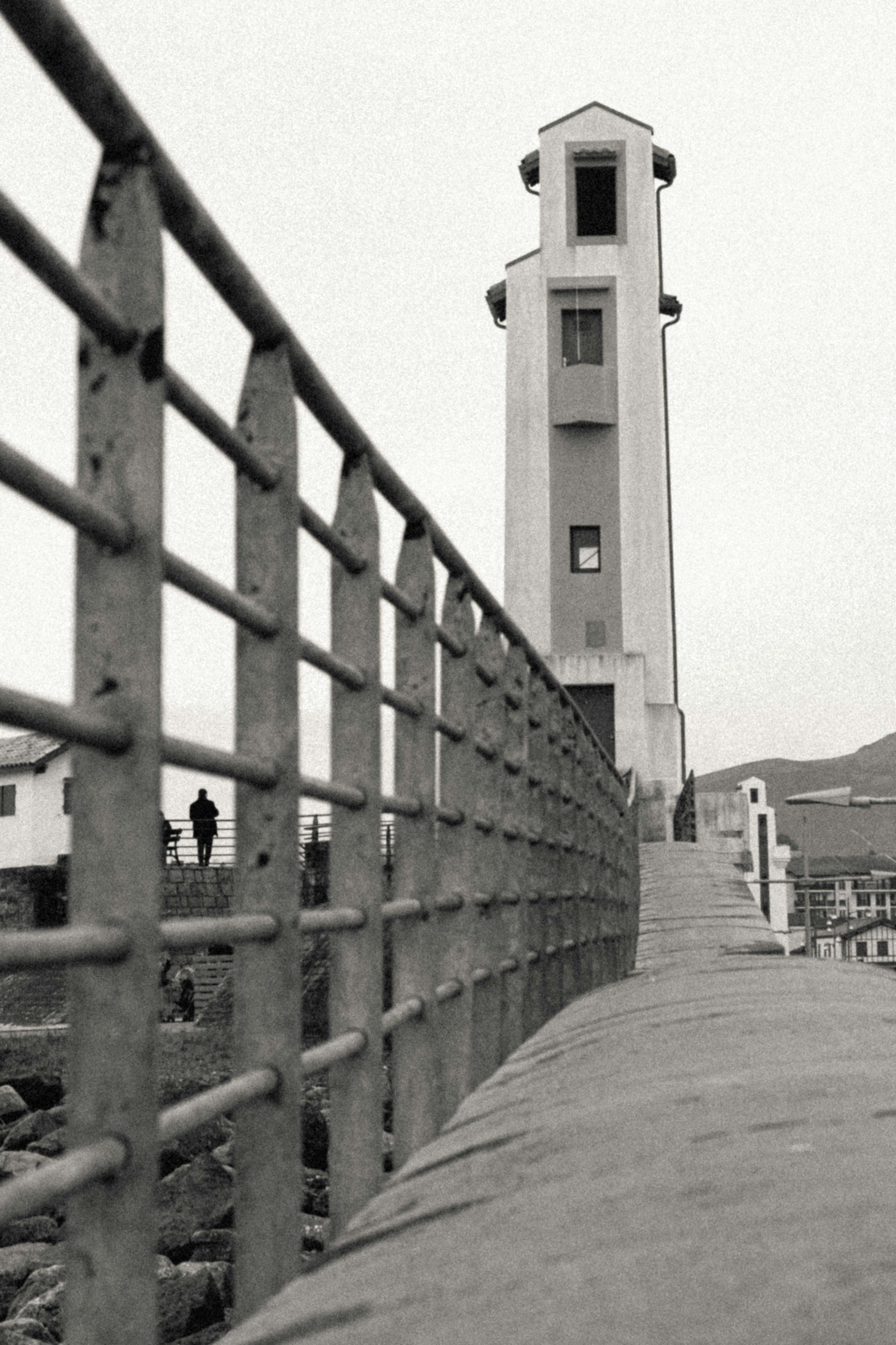 Railing and Lighthouse behind in Black and White · Free Stock Photo
