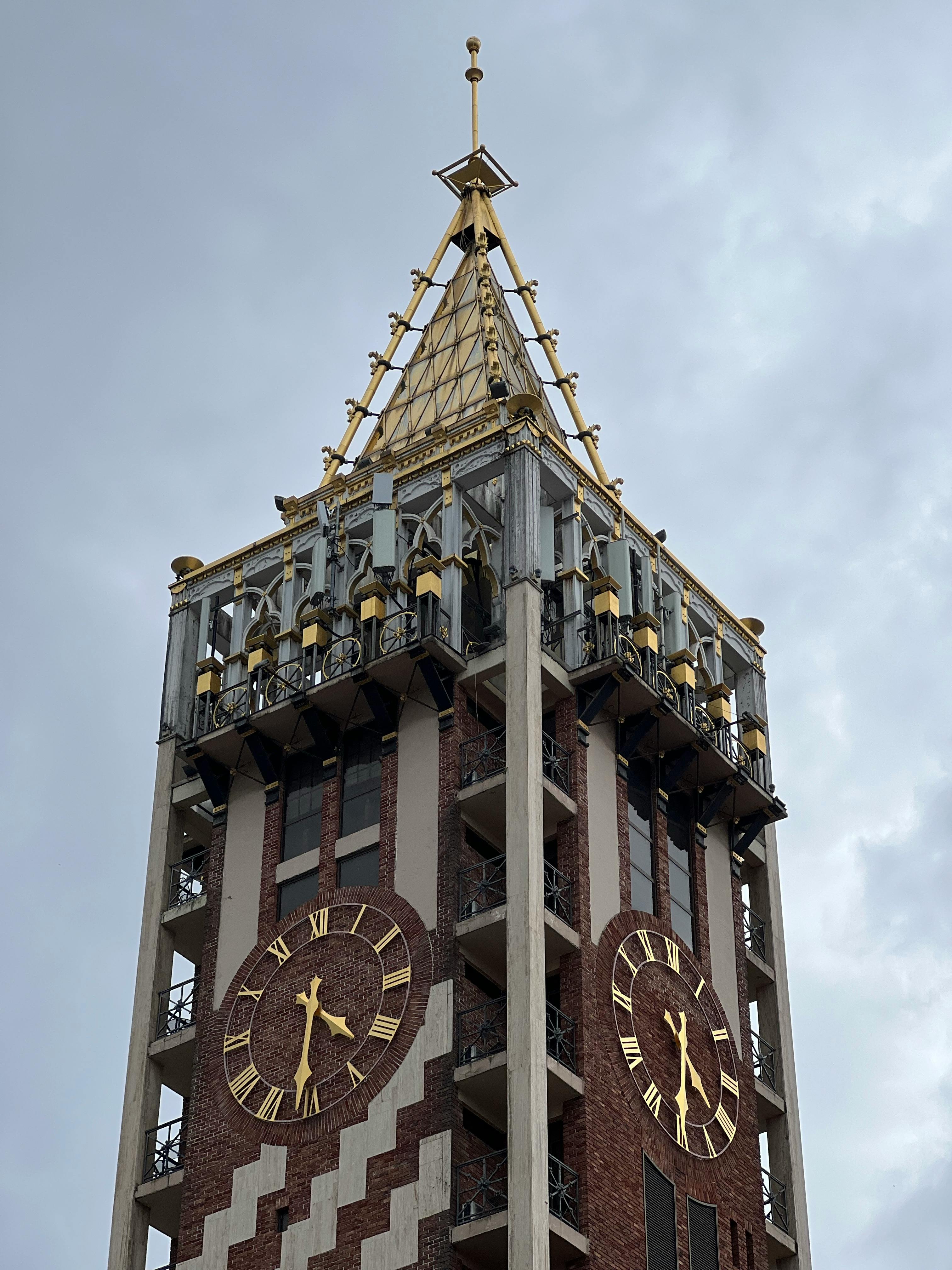 A tall clock tower with two gold clocks · Free Stock Photo